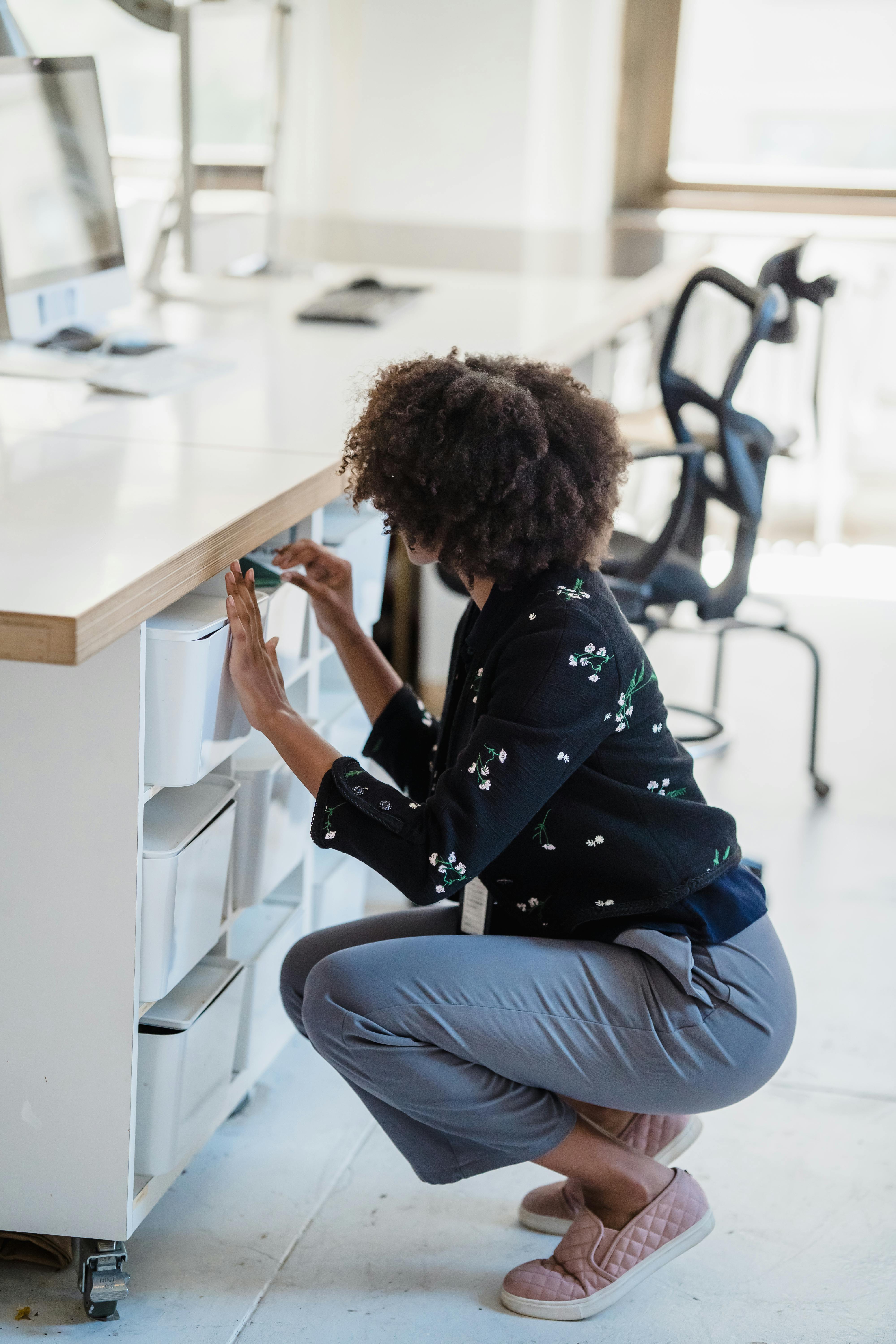 Woman Crouching and Looking for Something in a Box in an Office Desk ...