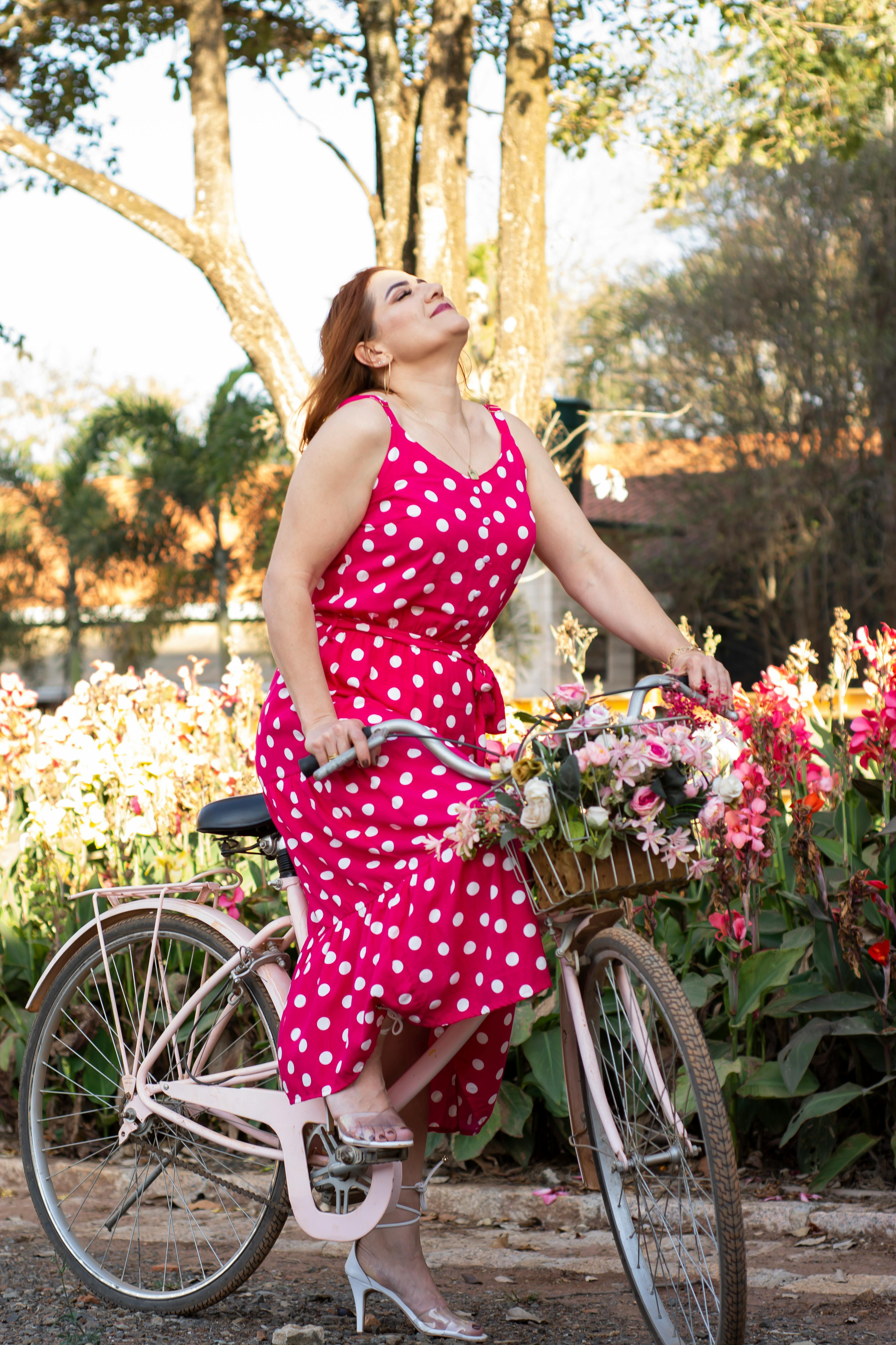 A Woman in Red and White Polka Dot Dress Riding a Bicycle · Free Stock ...