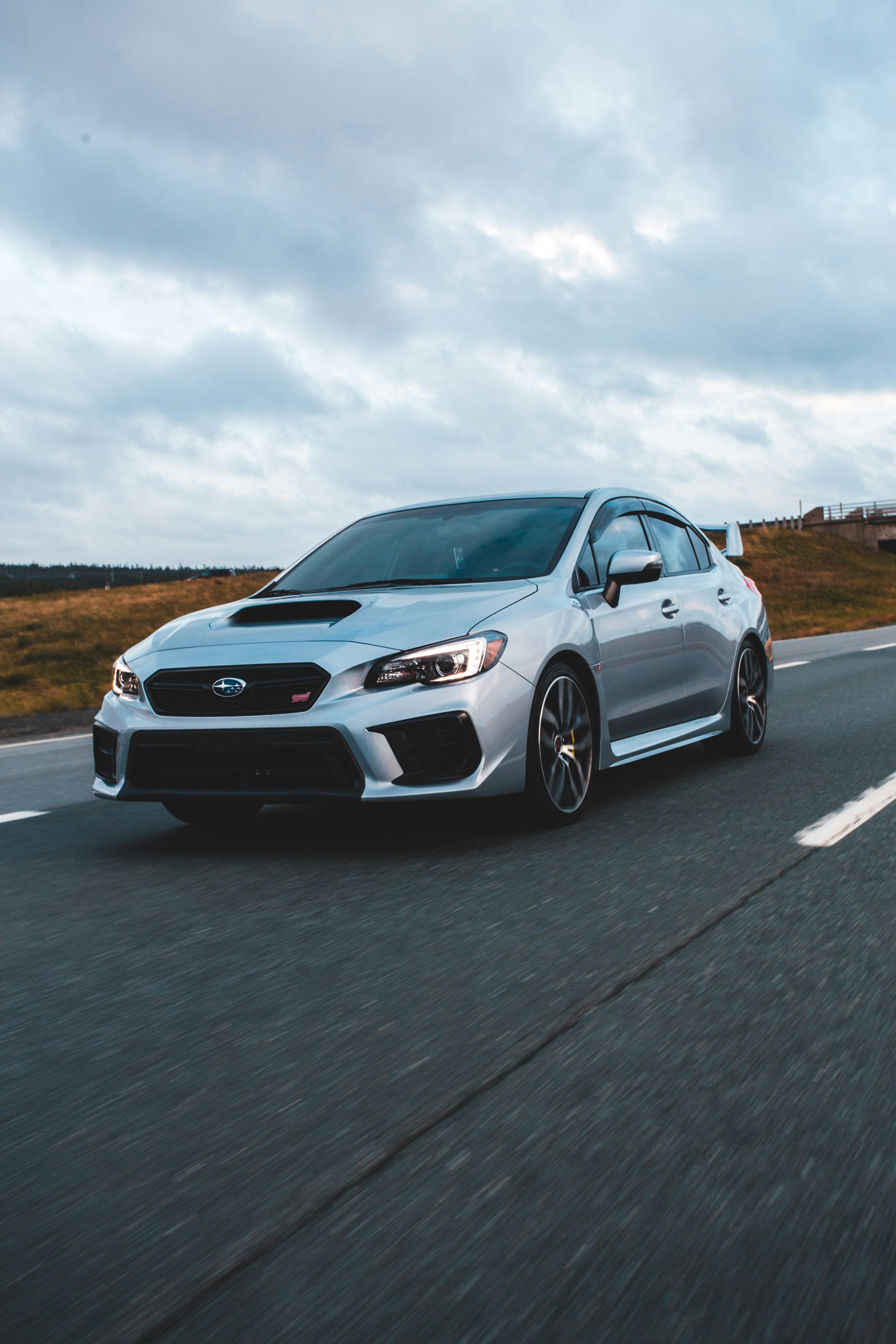 Silver Car on an Asphalt Road and Overcast in Sky · Free Stock Photo