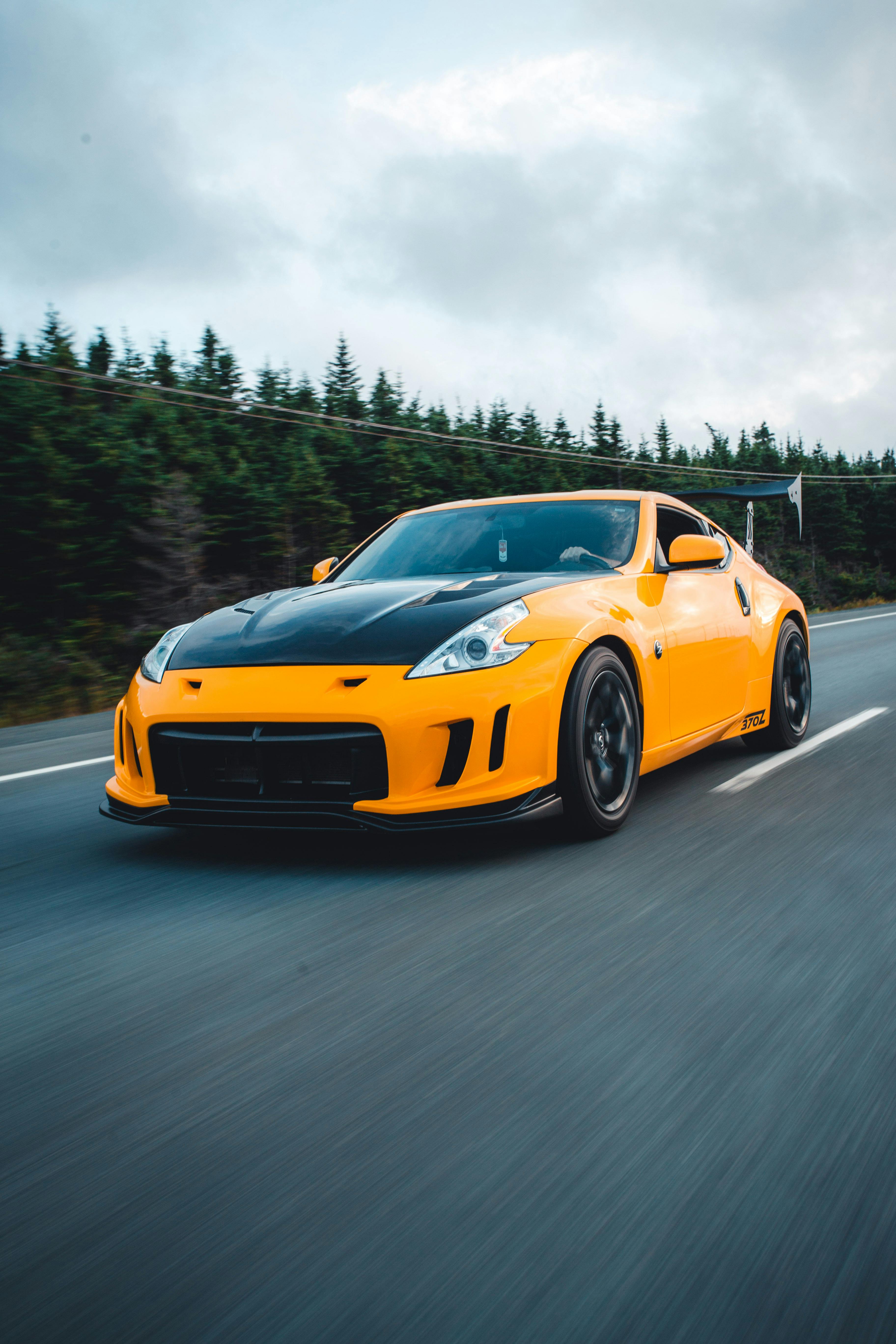 Yellow Sportscar Driving Down the Road · Free Stock Photo