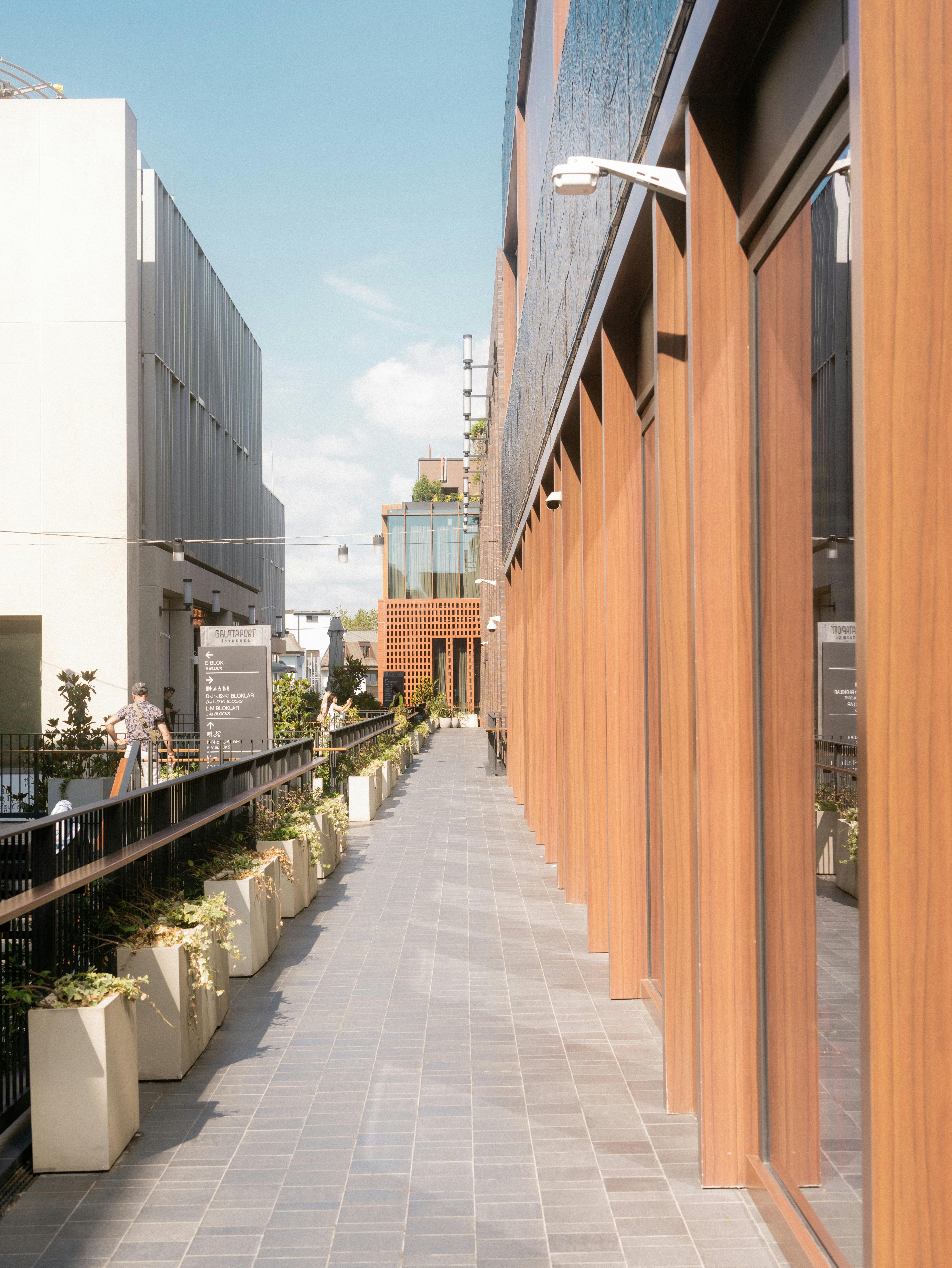 Narrow Sidewalk between Building and Fence Decorated with Flower Pots ...
