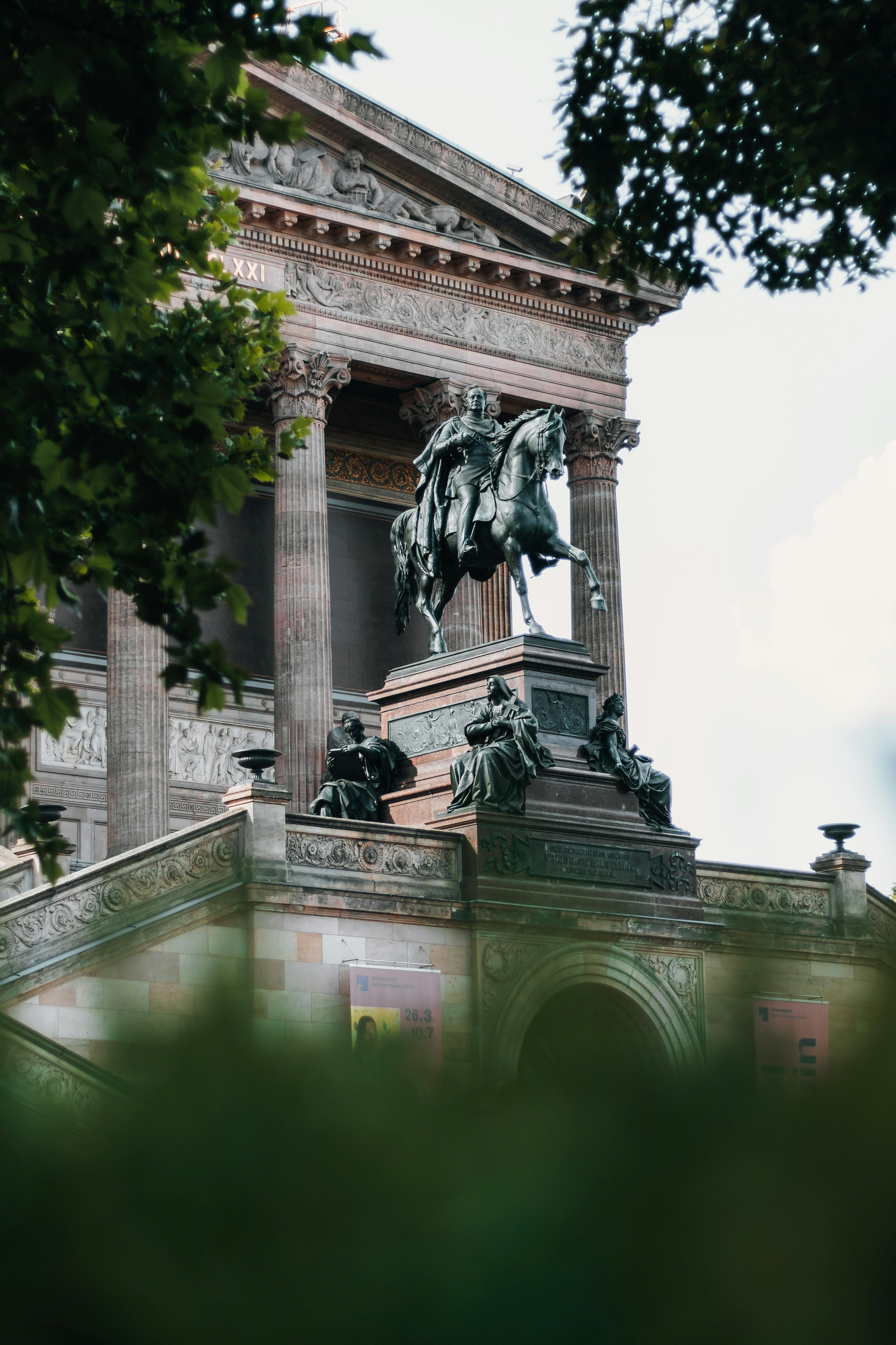 Bronze Sculpture in Front of Classicist Building · Free Stock Photo