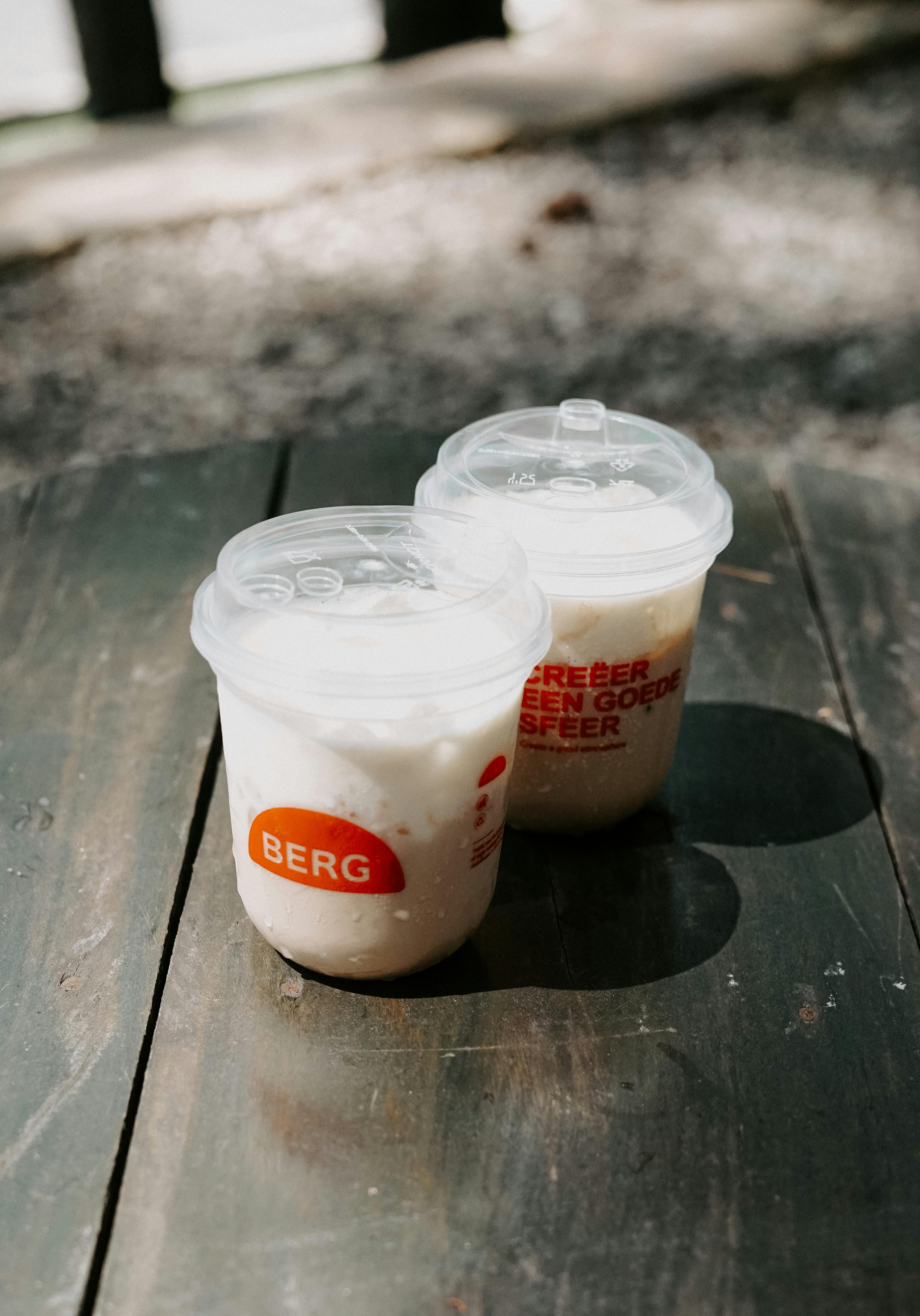 Disposable Plastic Cups of Milkshake on Green Grass · Free Stock Photo