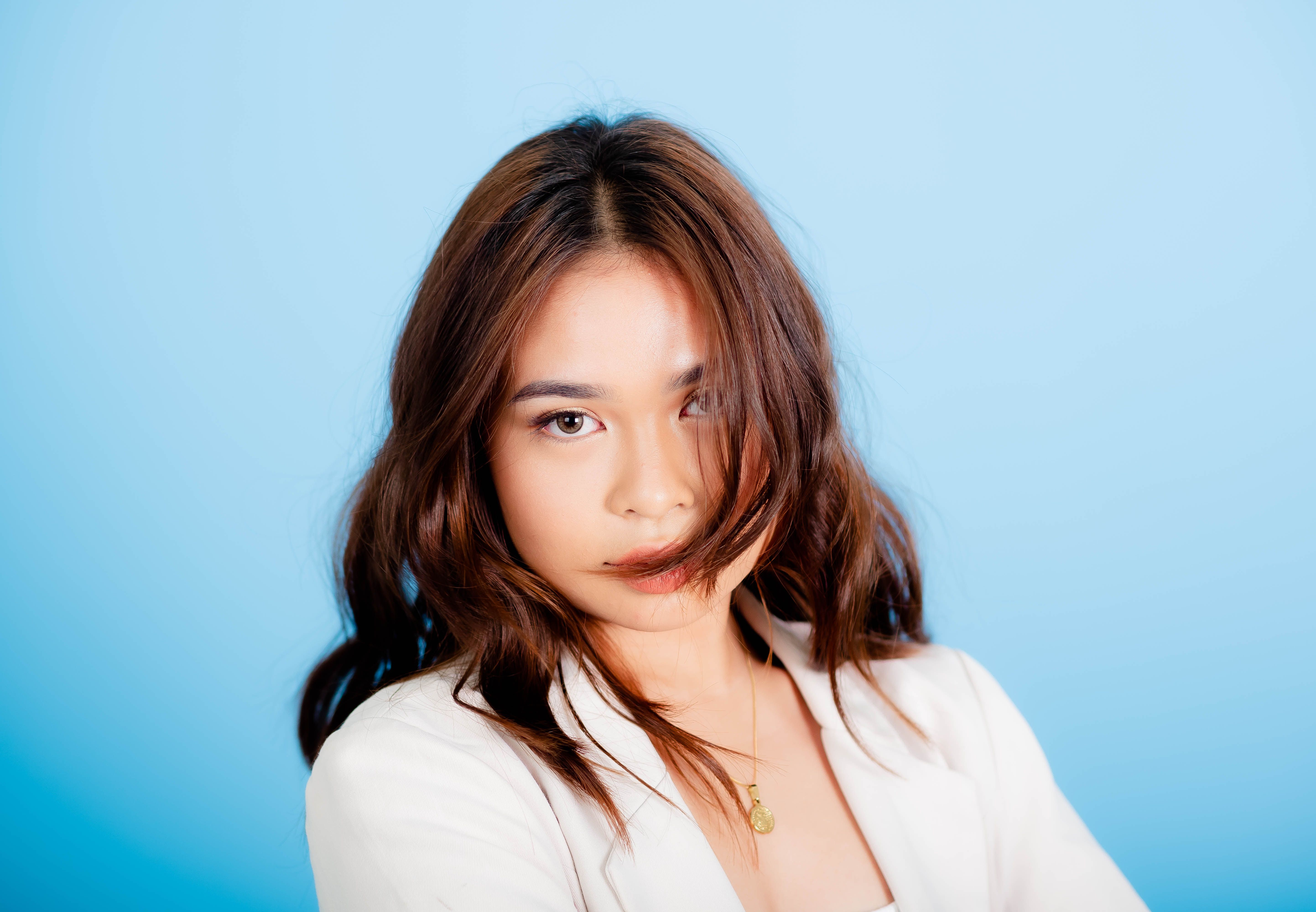 Young Woman Posing in Blue Studio Background · Free Stock Photo