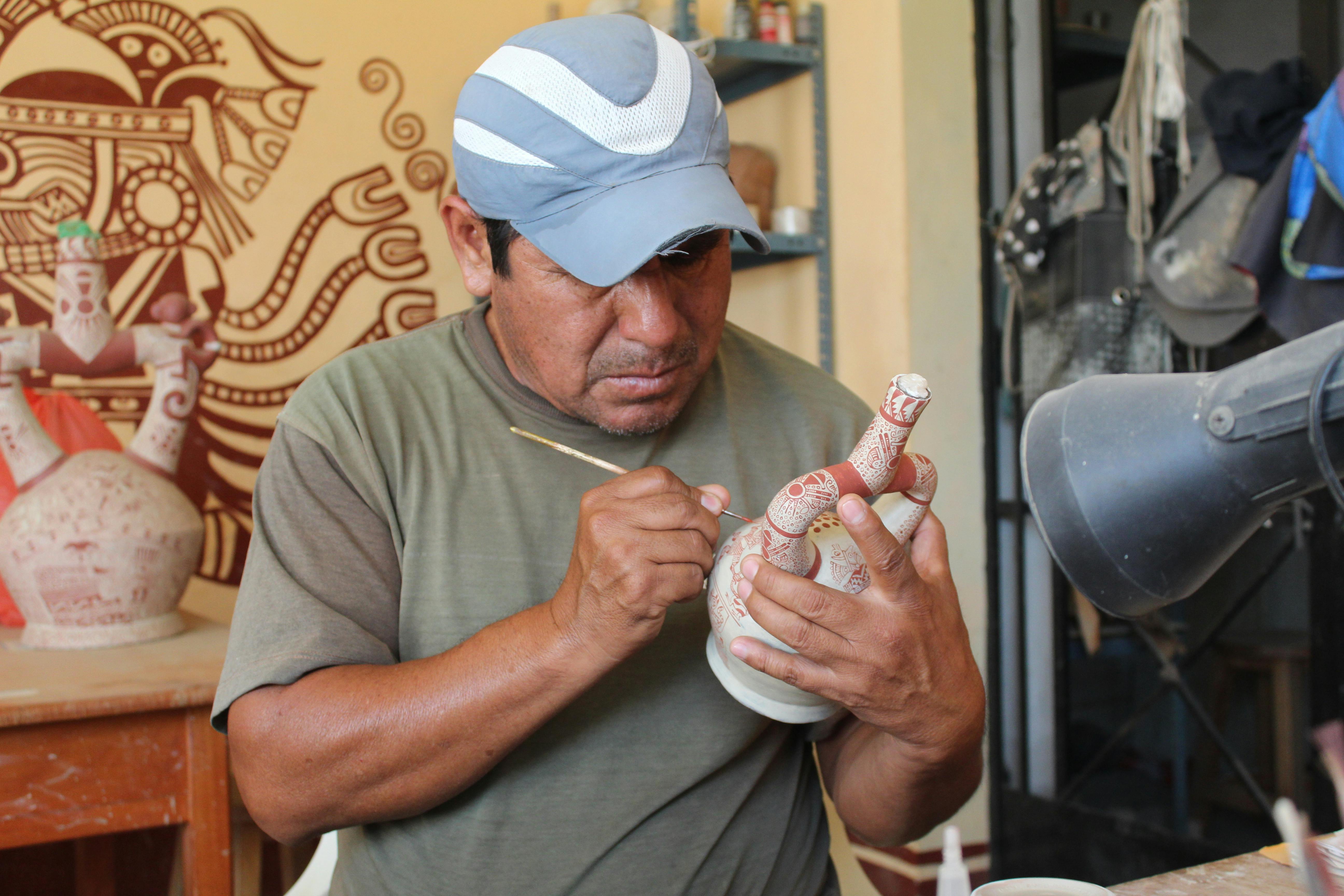 A Man Painting a Ceramic Vase · Free Stock Photo