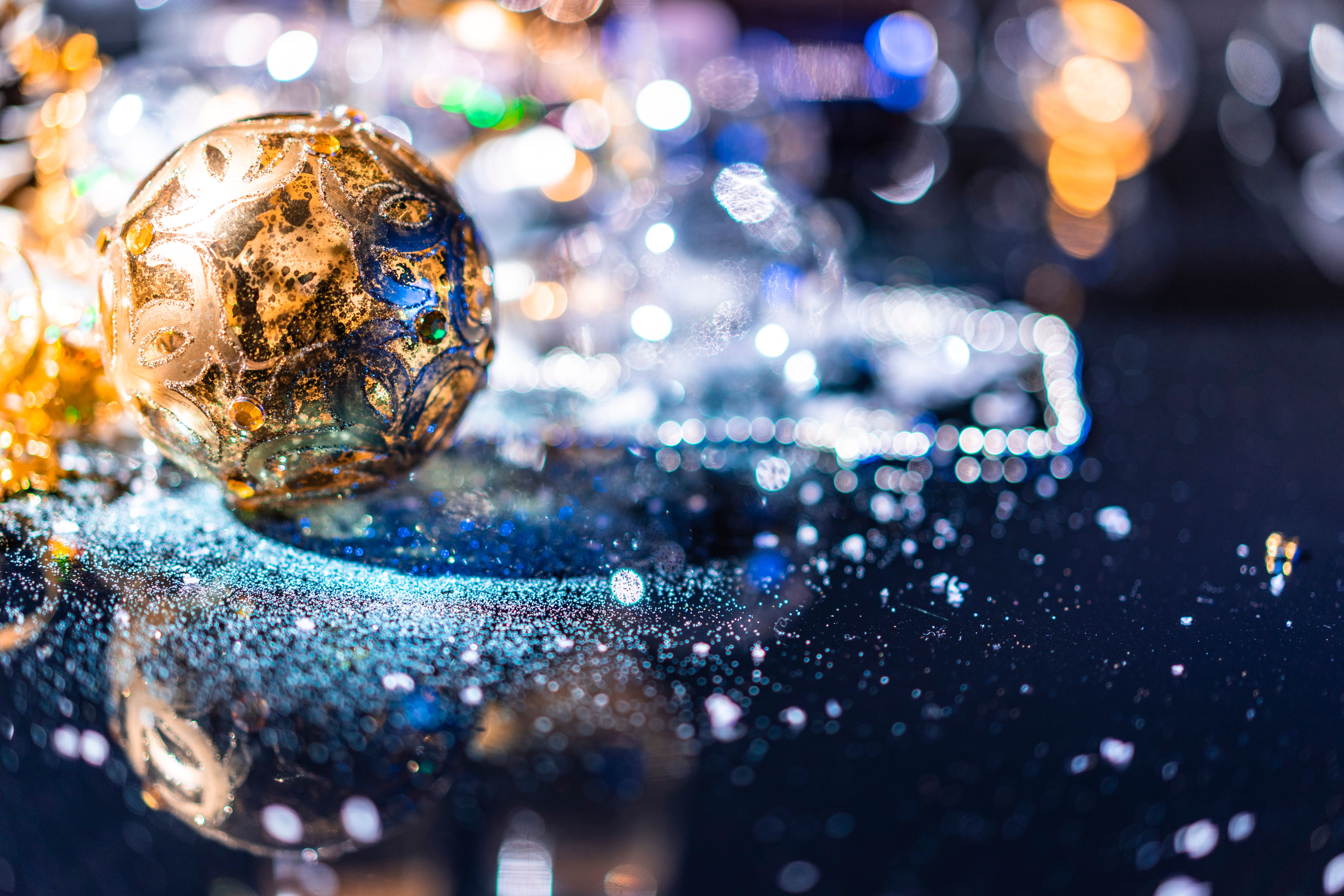 A Gold Christmas Bauble on Glass Surface · Free Stock Photo