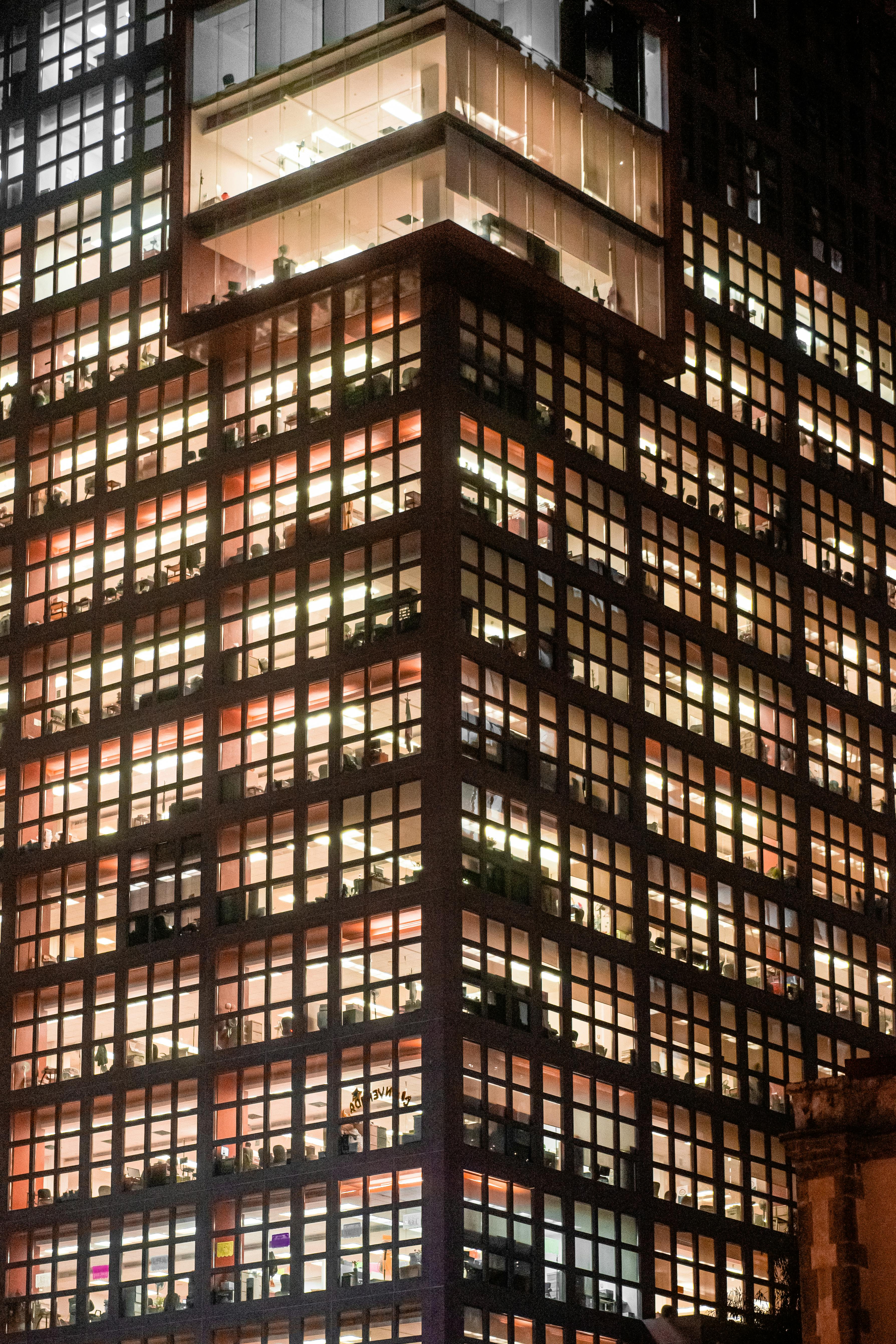 Exterior of Glass Windows of a Tall Building at Night · Free Stock Photo