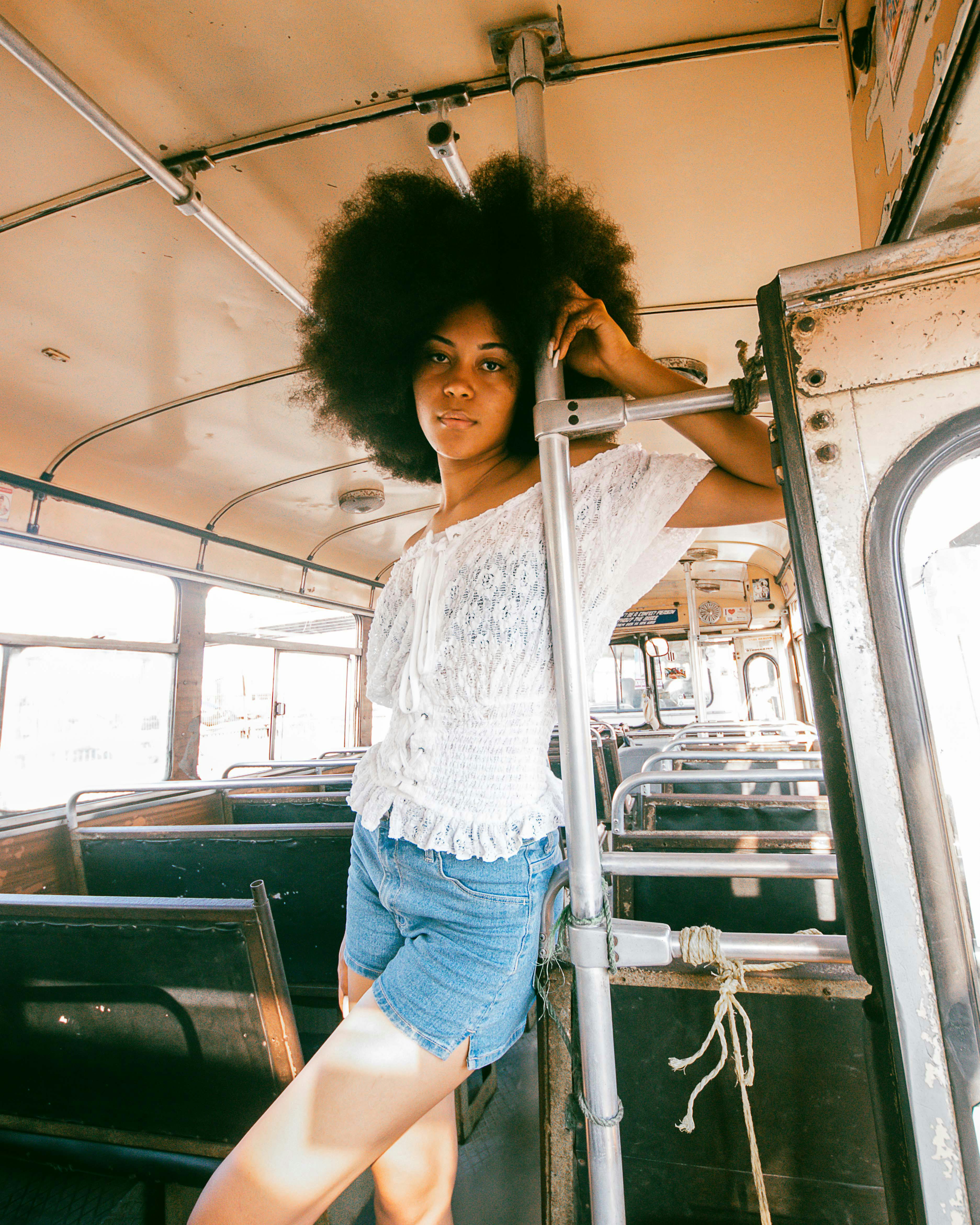 A Woman with Afro Hair Leaning on a Bus Railing · Free Stock Photo