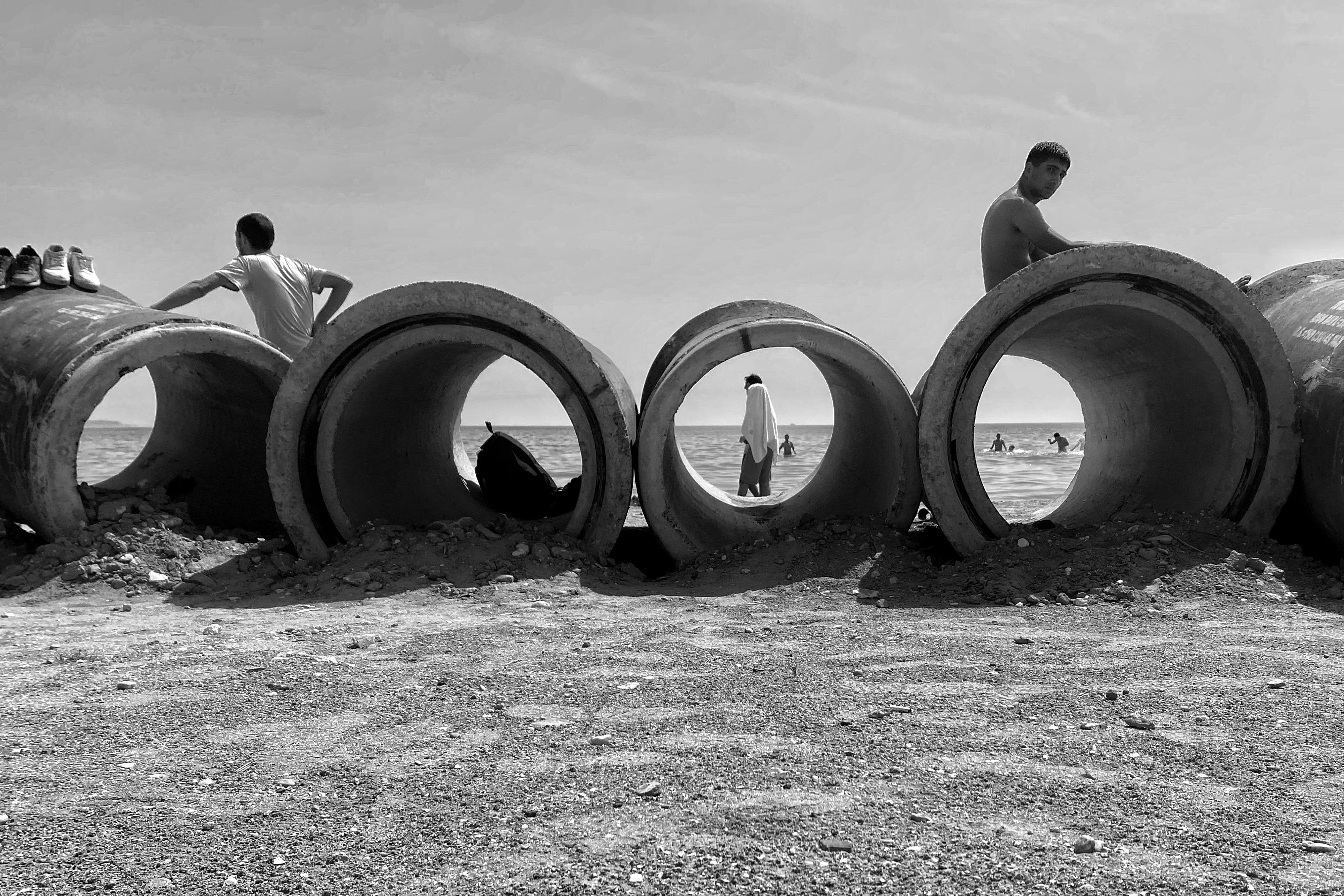 Kids on Concrete Tubes on Beach · Free Stock Photo