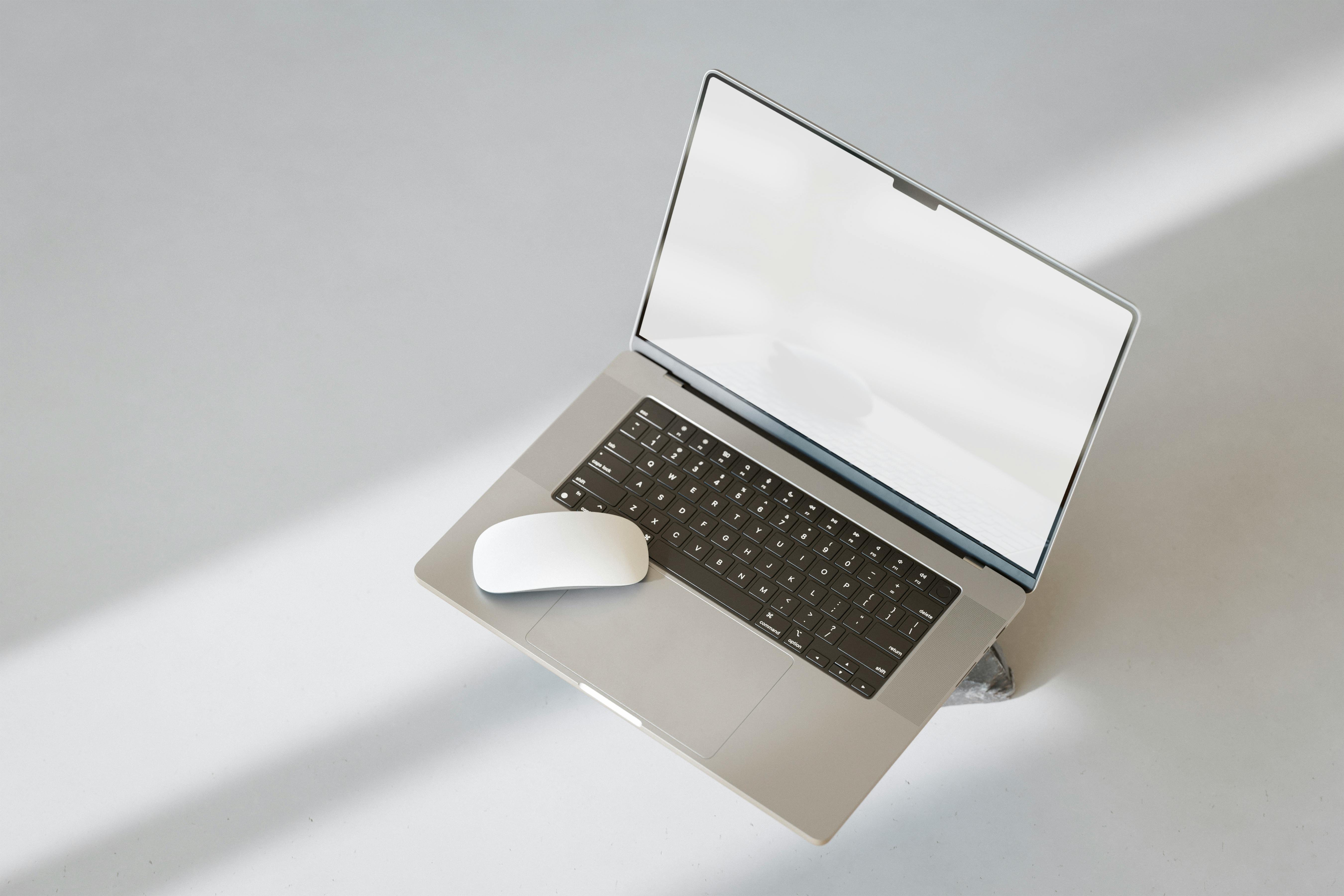 High Angle Shot of Laptop and Mouse on White Surface · Free Stock Photo
