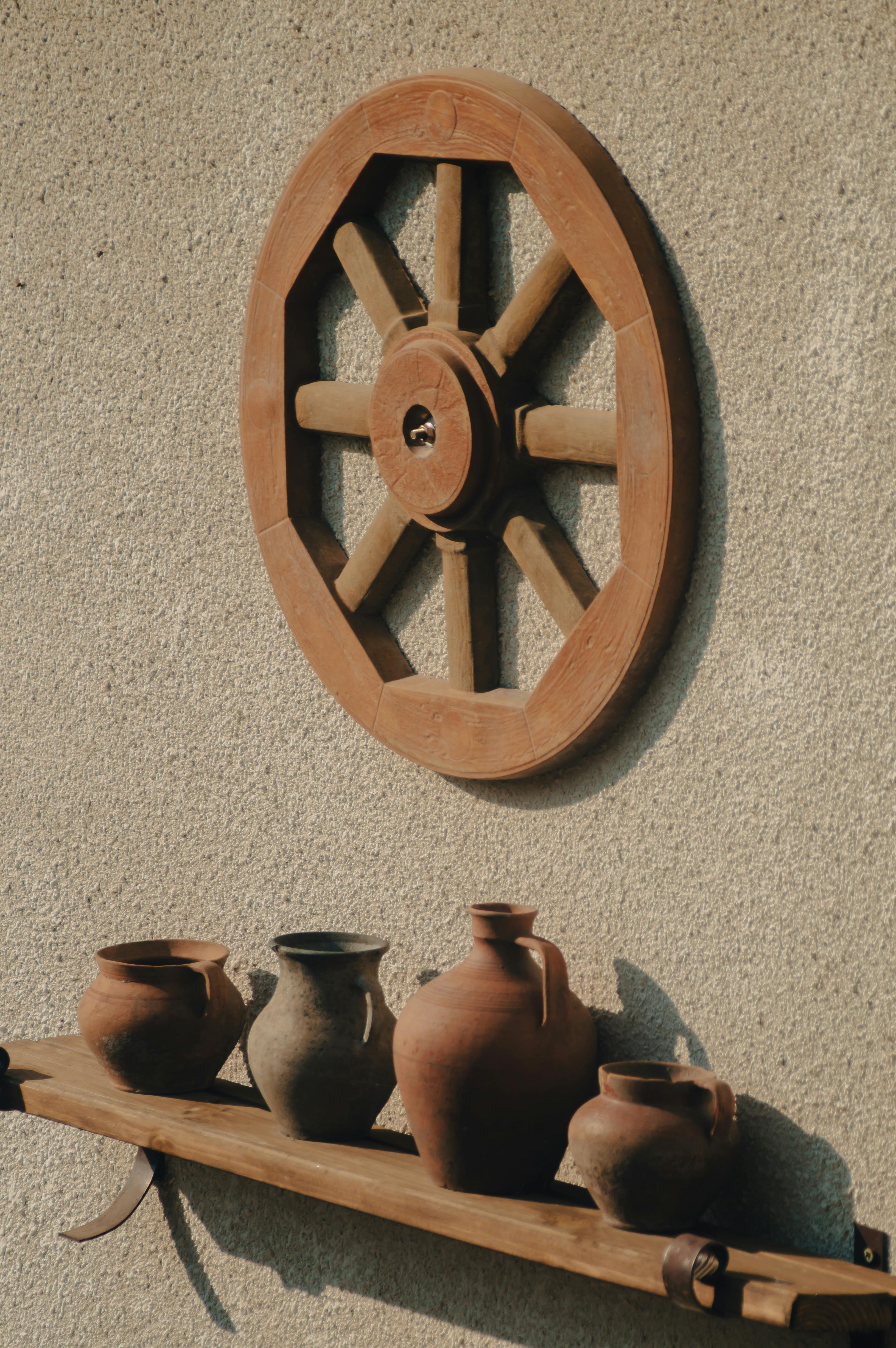 Brown Wooden Wheel on Concrete Wall · Free Stock Photo