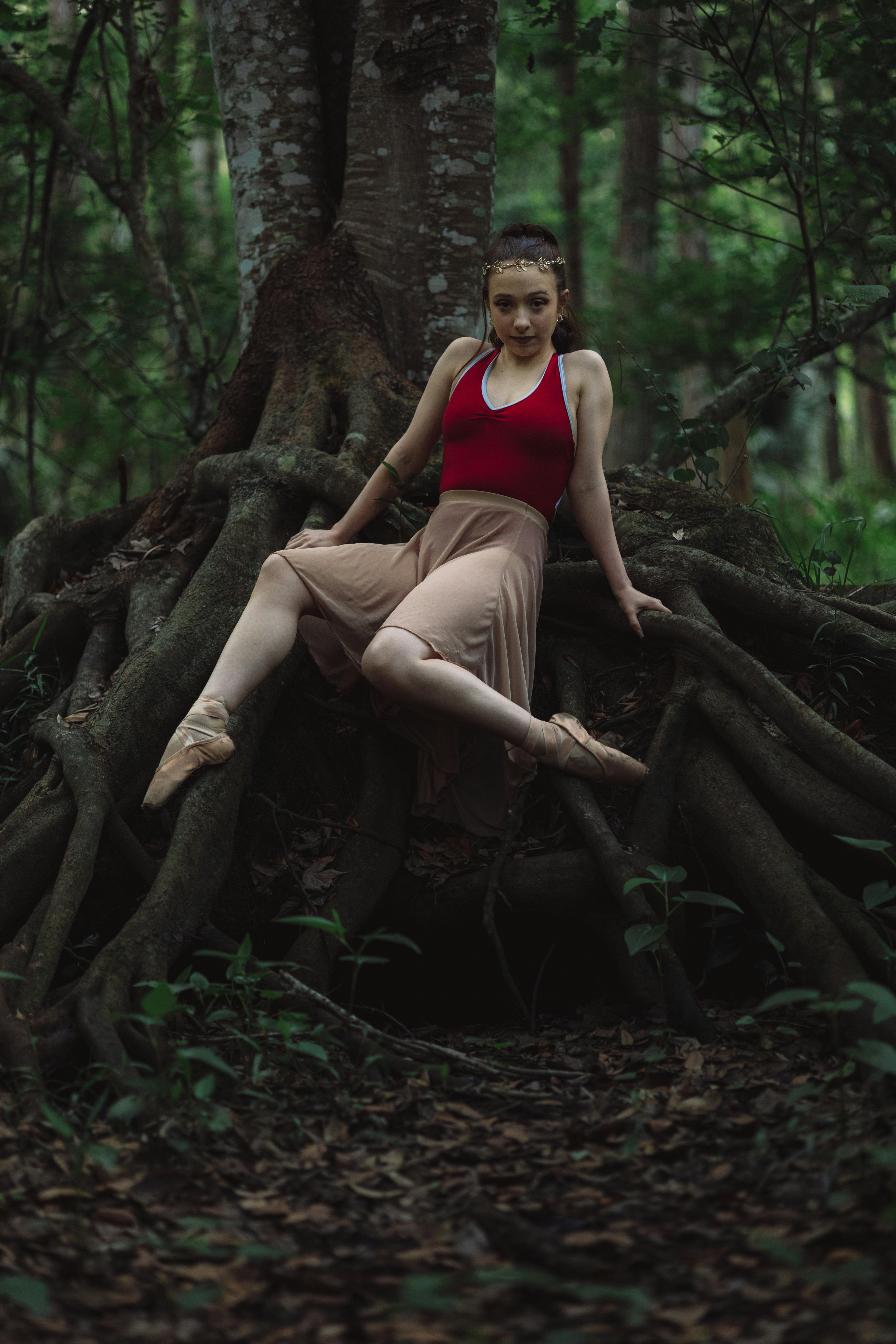 Ballerina Sitting on Tree Roots in Forest · Free Stock Photo