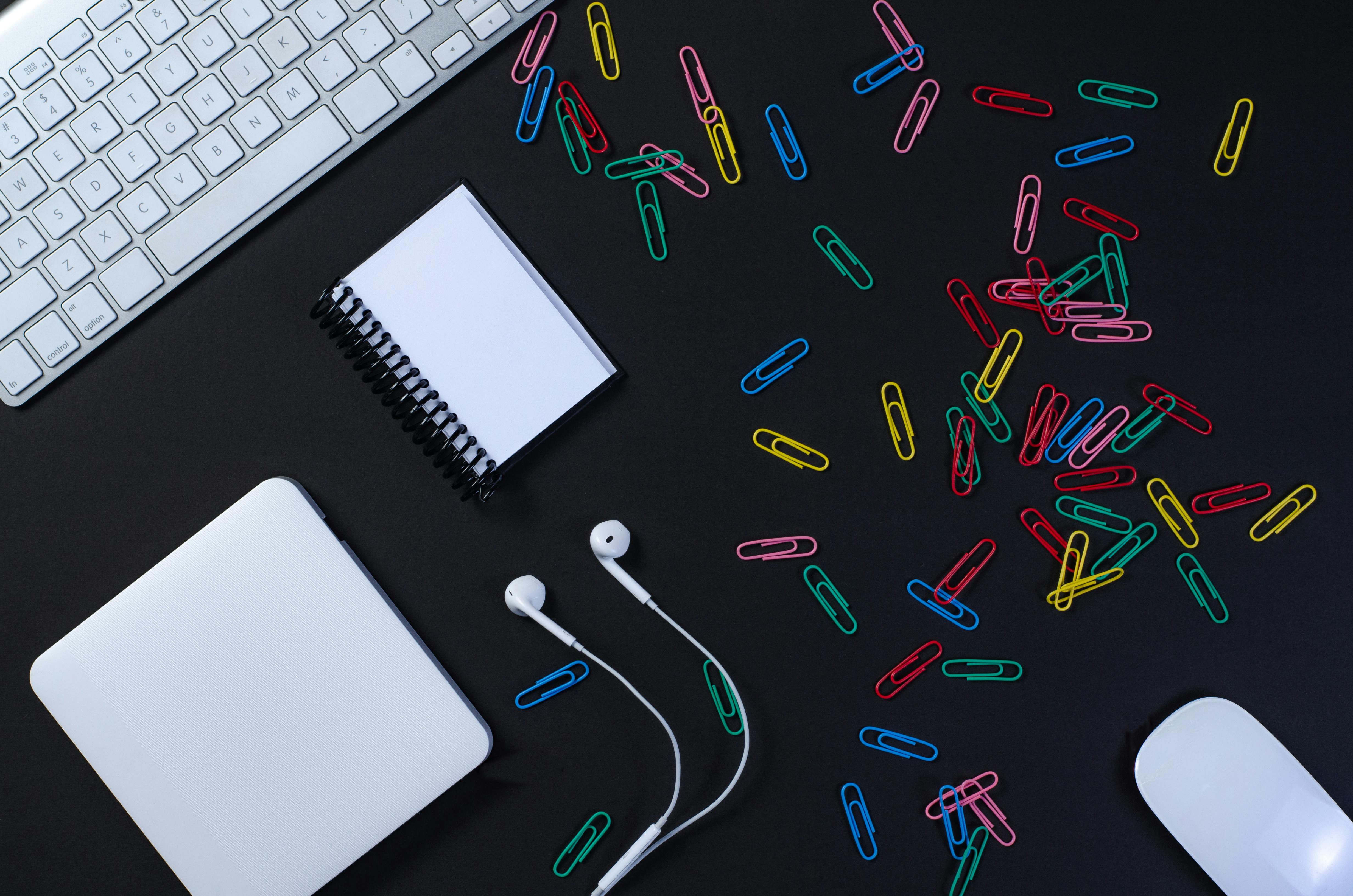 Colorful Paperclips Scattered on Desk with White Notebook and Keyboard ...