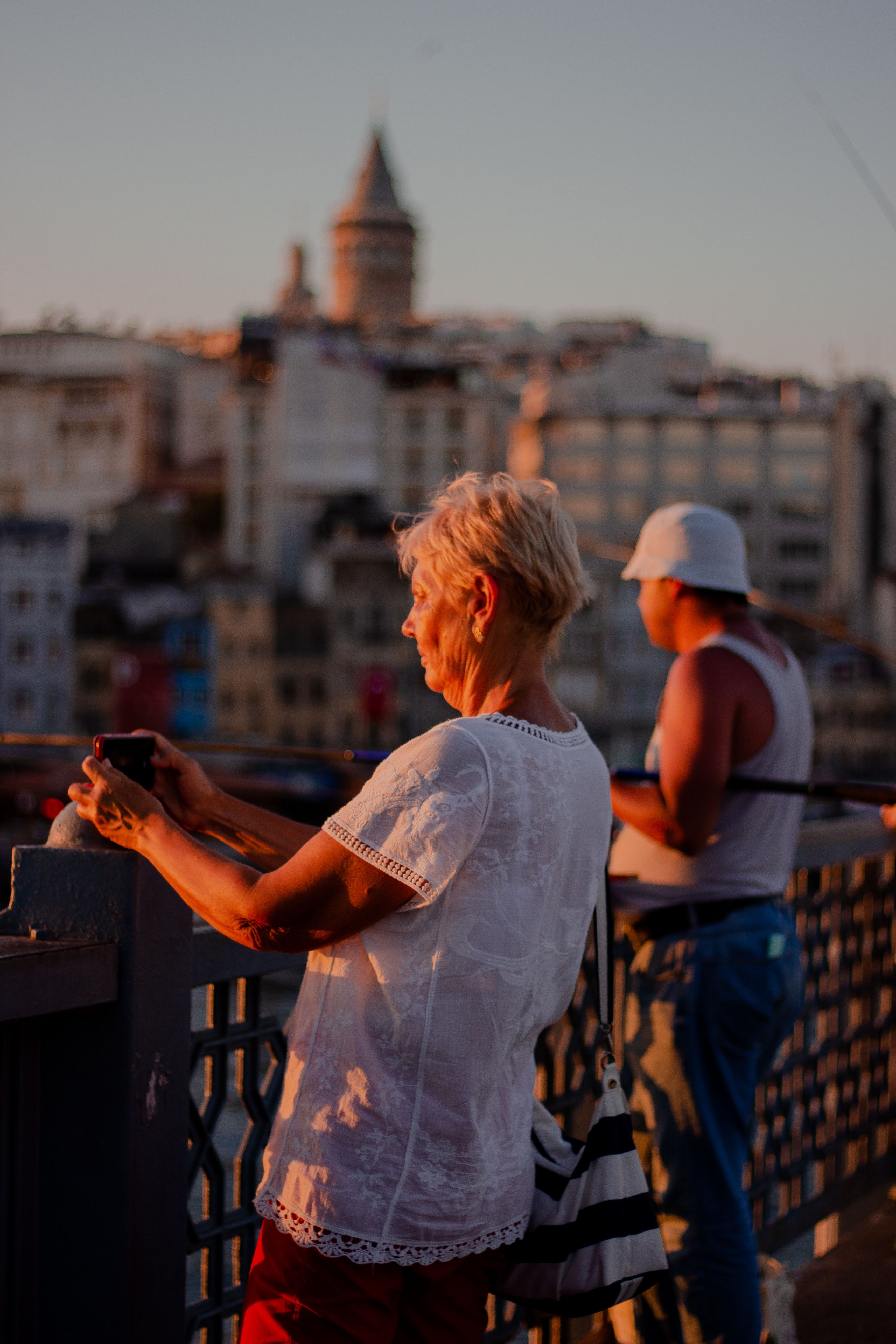 Elderly Woman Taking Photo from Bridge in Istanbul, Turkey at Sunset ...