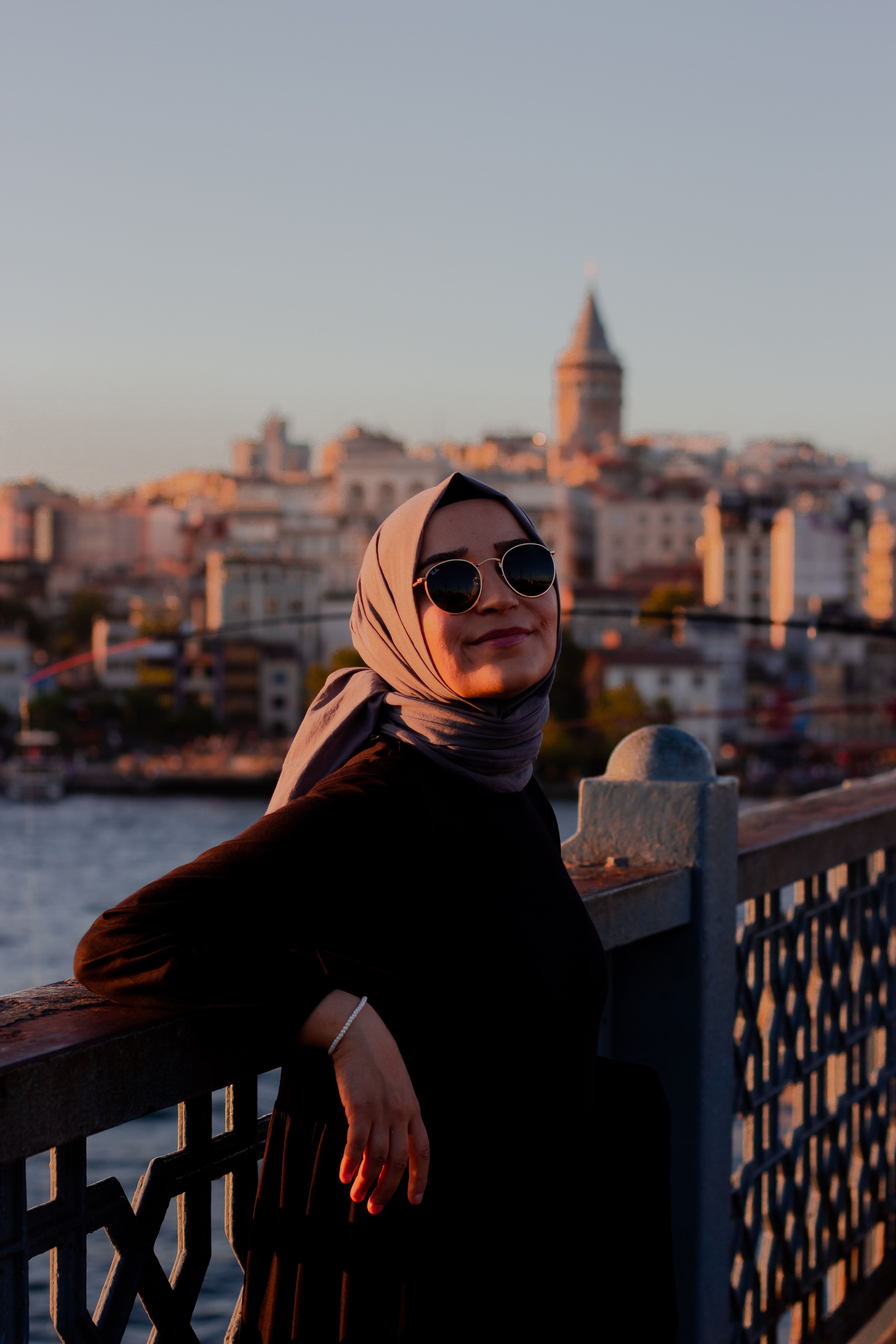 Woman in Brown Hijab Leaning on Bridge Railing while Smiling · Free ...
