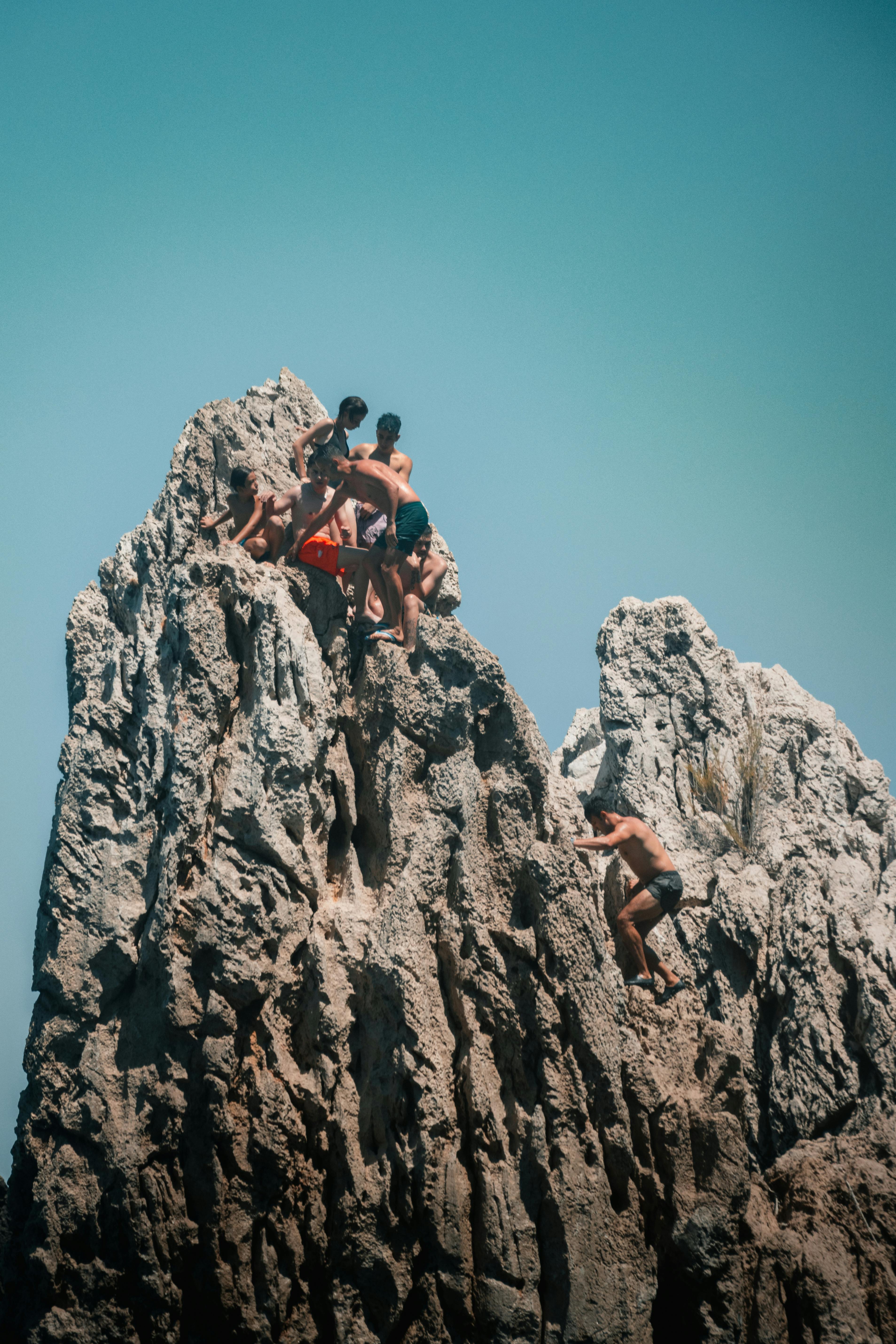 A Group of People Climbing on Gray Rocky Mountain · Free Stock Photo
