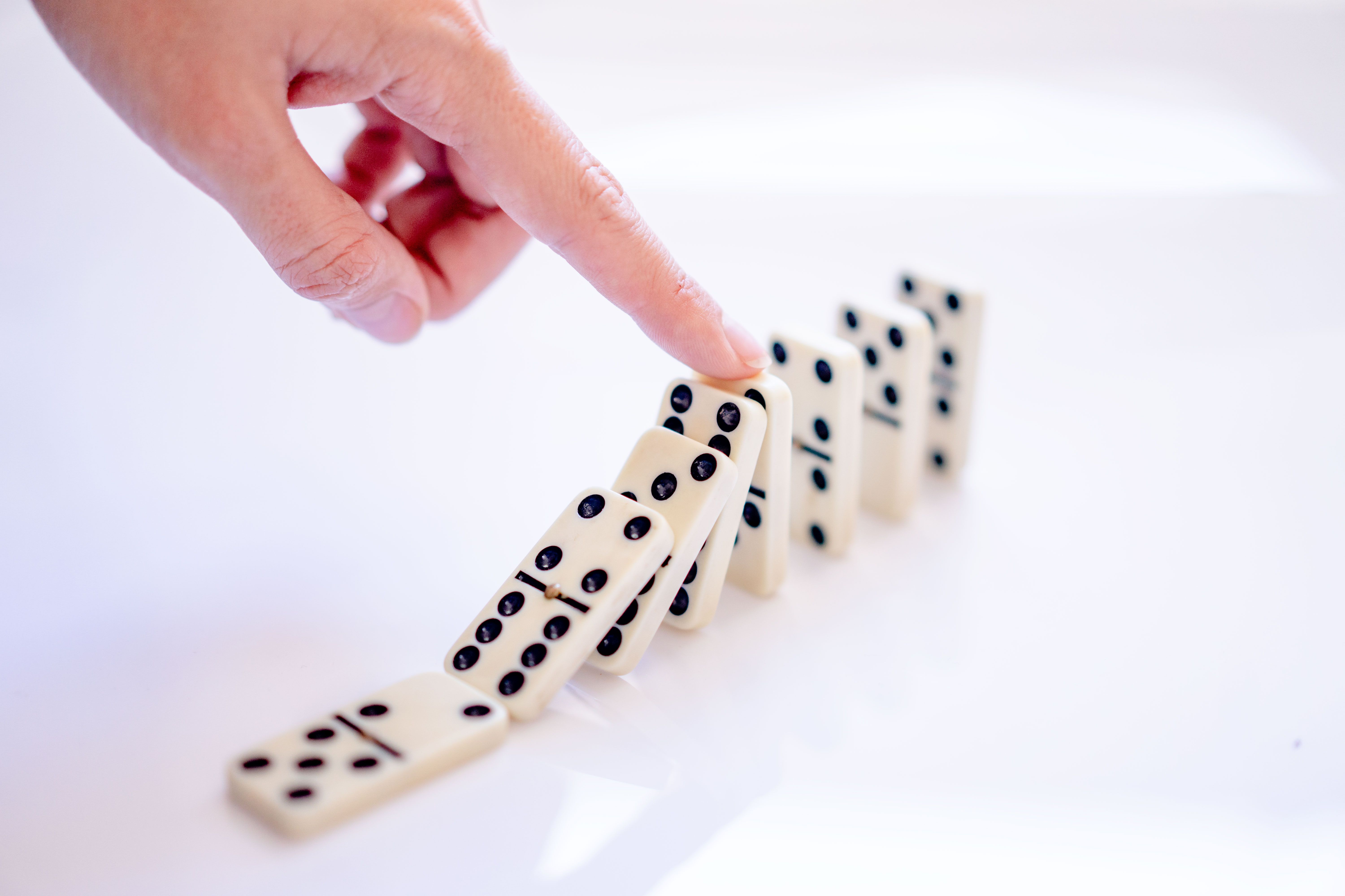 Domino blocks in a row and human hand trying to take one of it · Free ...