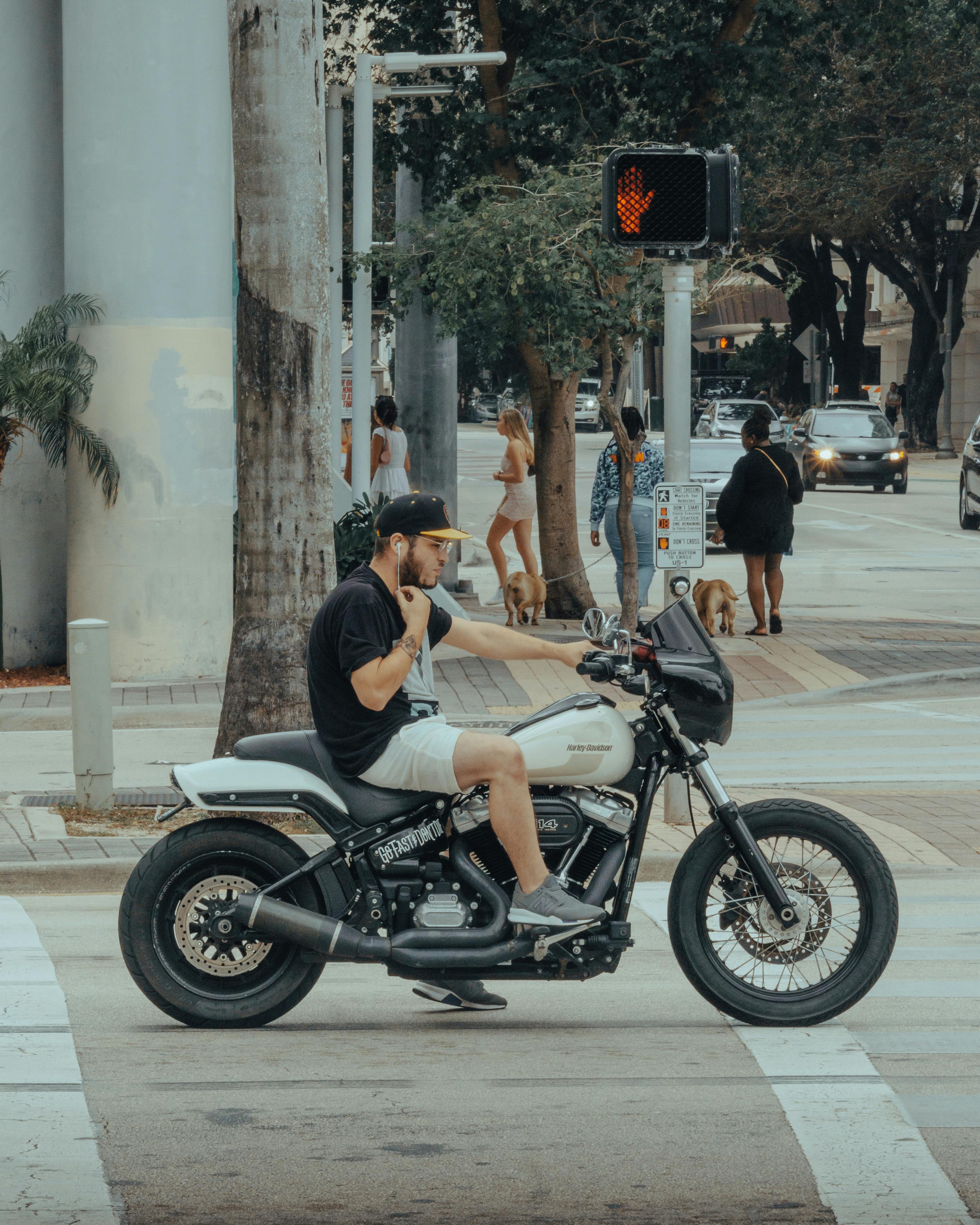 Man in Black Shirt and White Short Riding a Motorcycle · Free Stock Photo