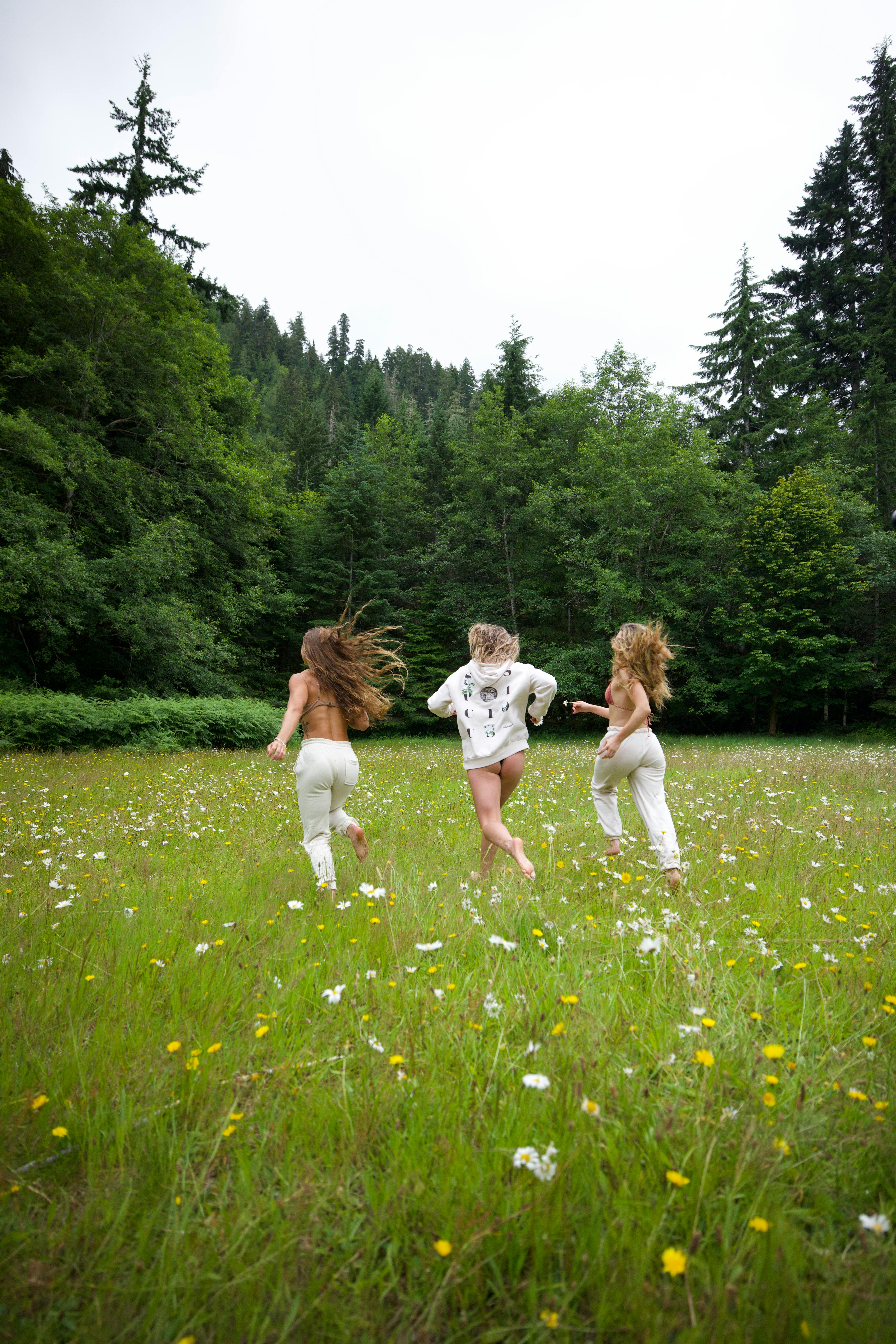Three Women Running on Flower Field · Free Stock Photo