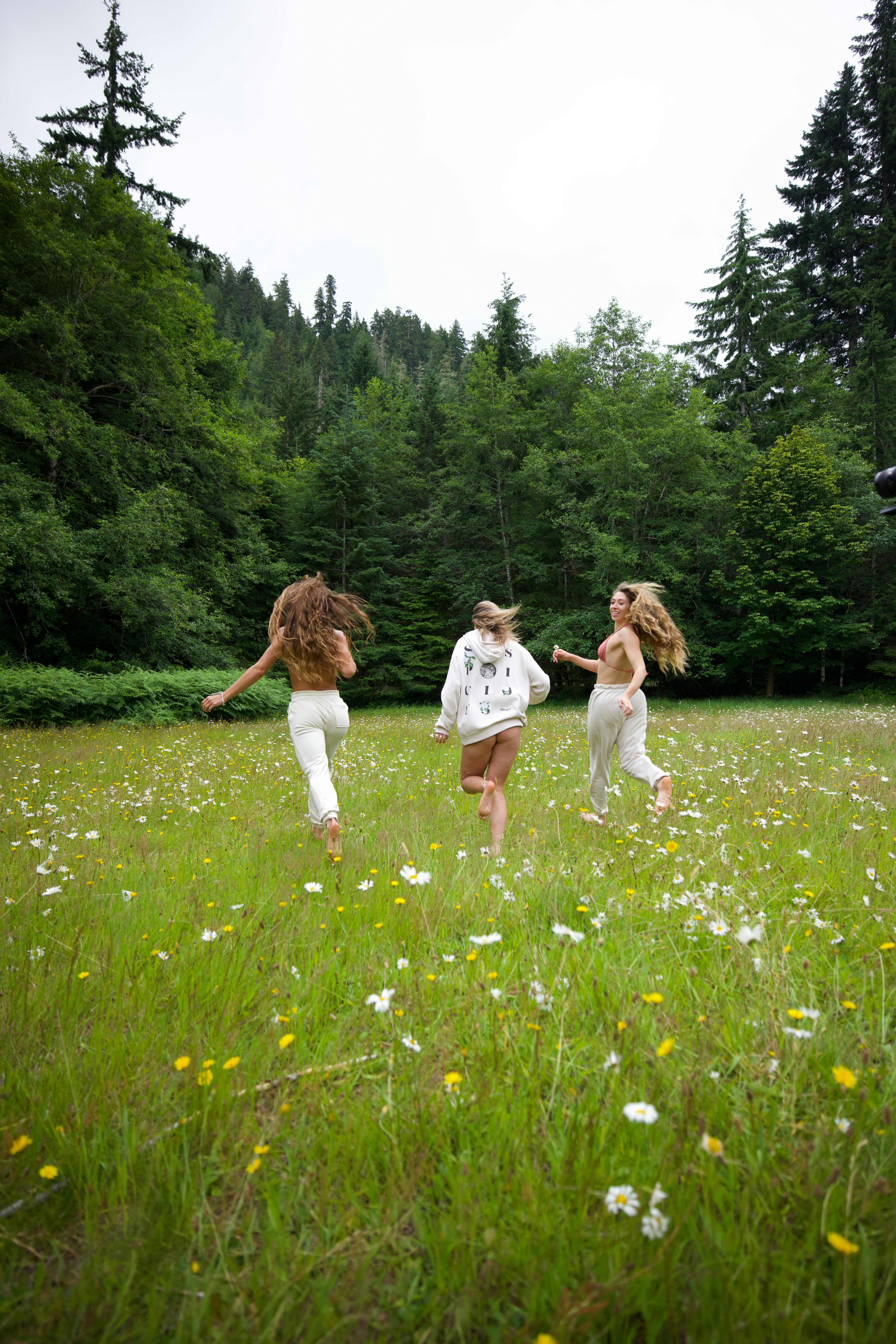 Three Women Running on Flower Field · Free Stock Photo