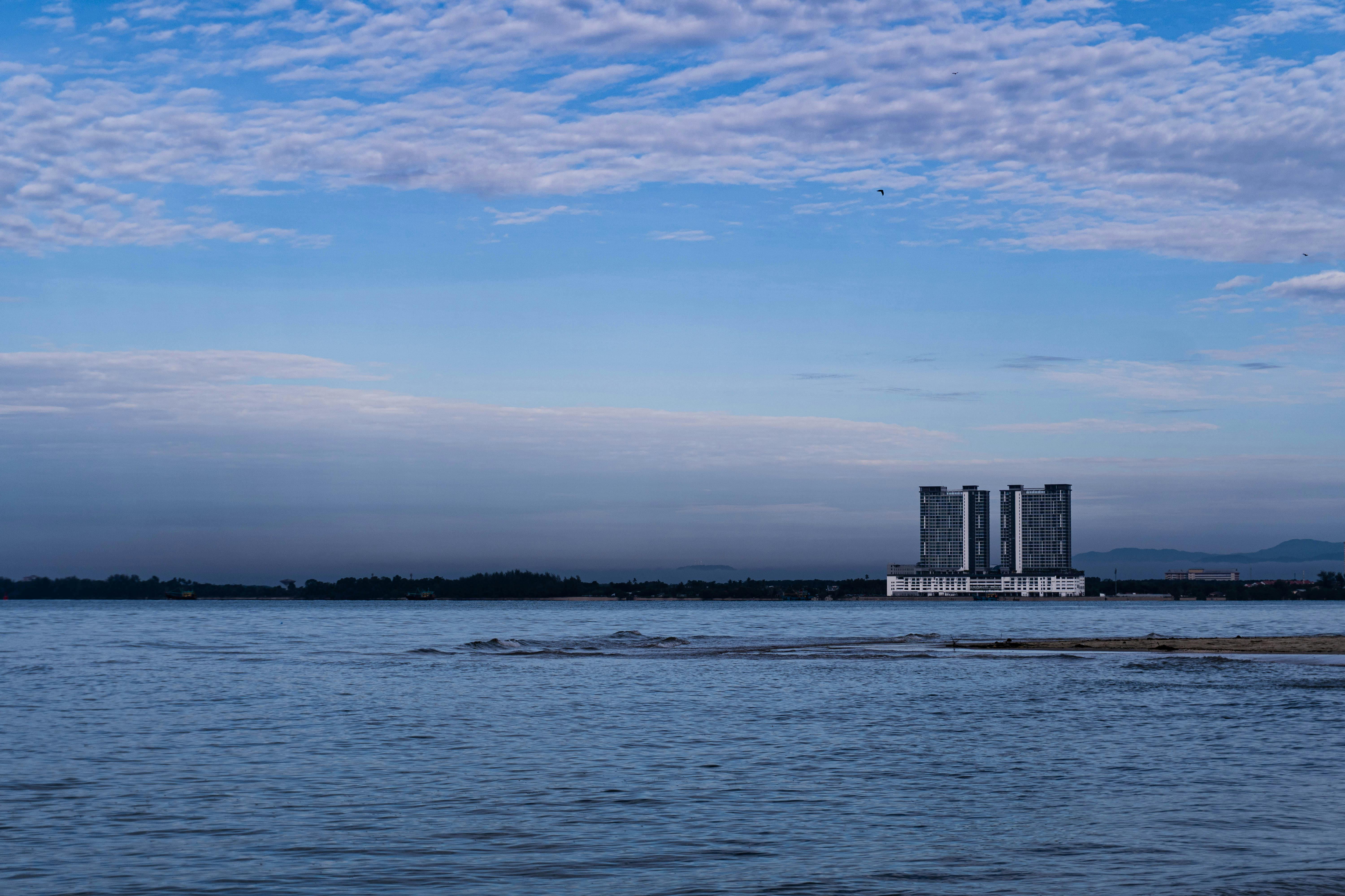 High Rise Building Near Sea Under Blue Sky · Free Stock Photo