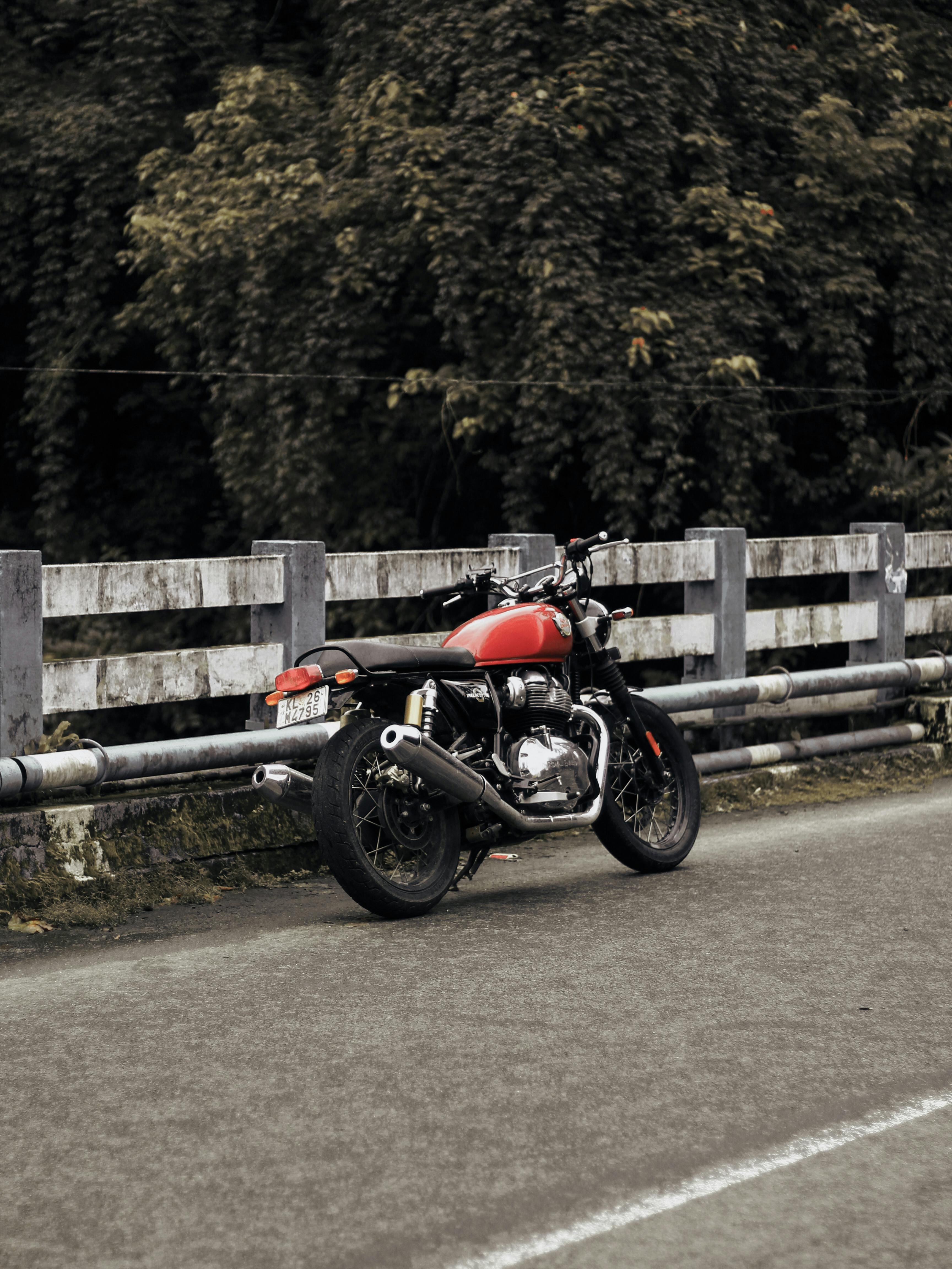 Motorcycle Parked Beside Concrete Fence · Free Stock Photo