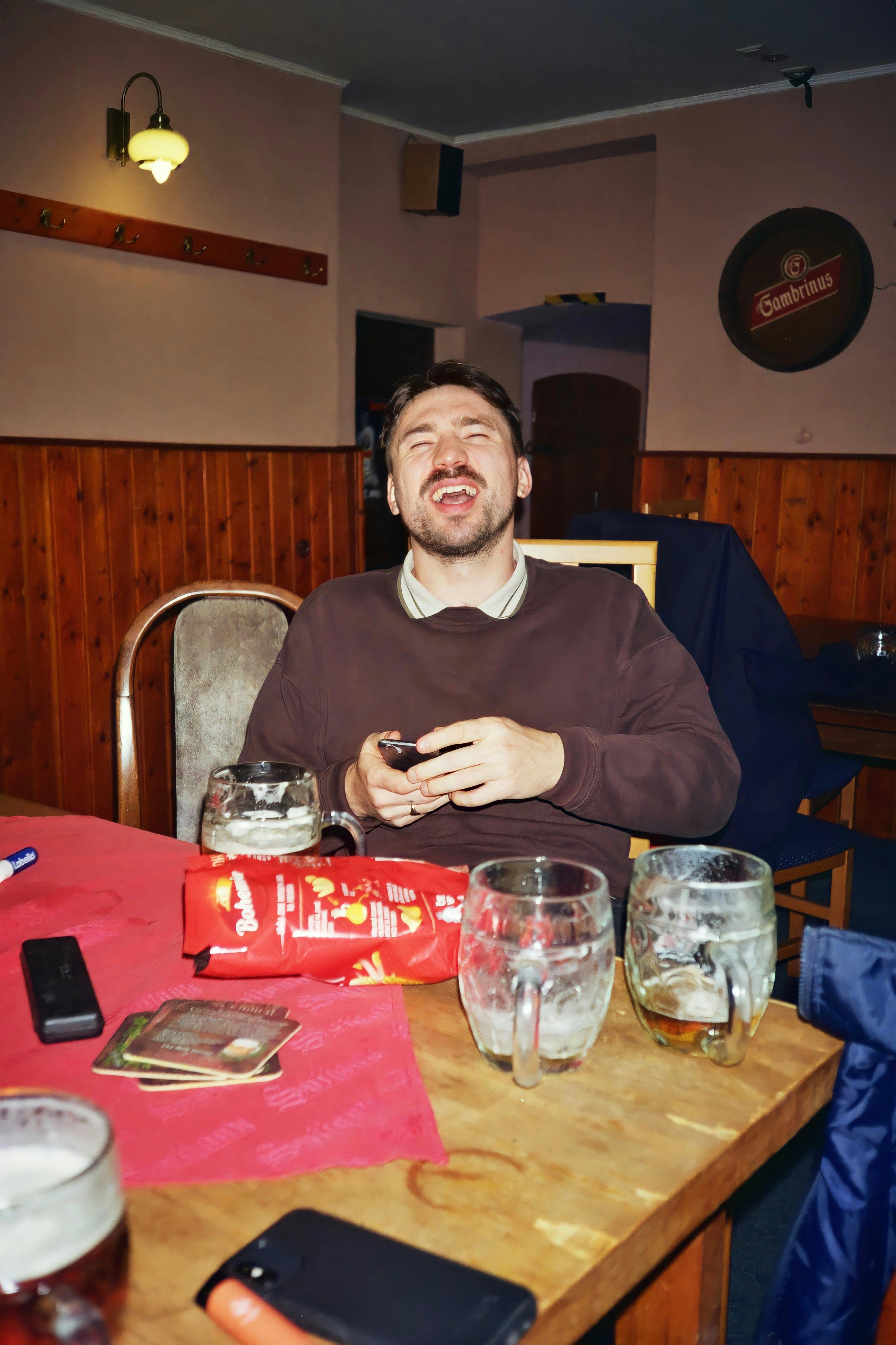 Laughing Man Sitting by Table · Free Stock Photo