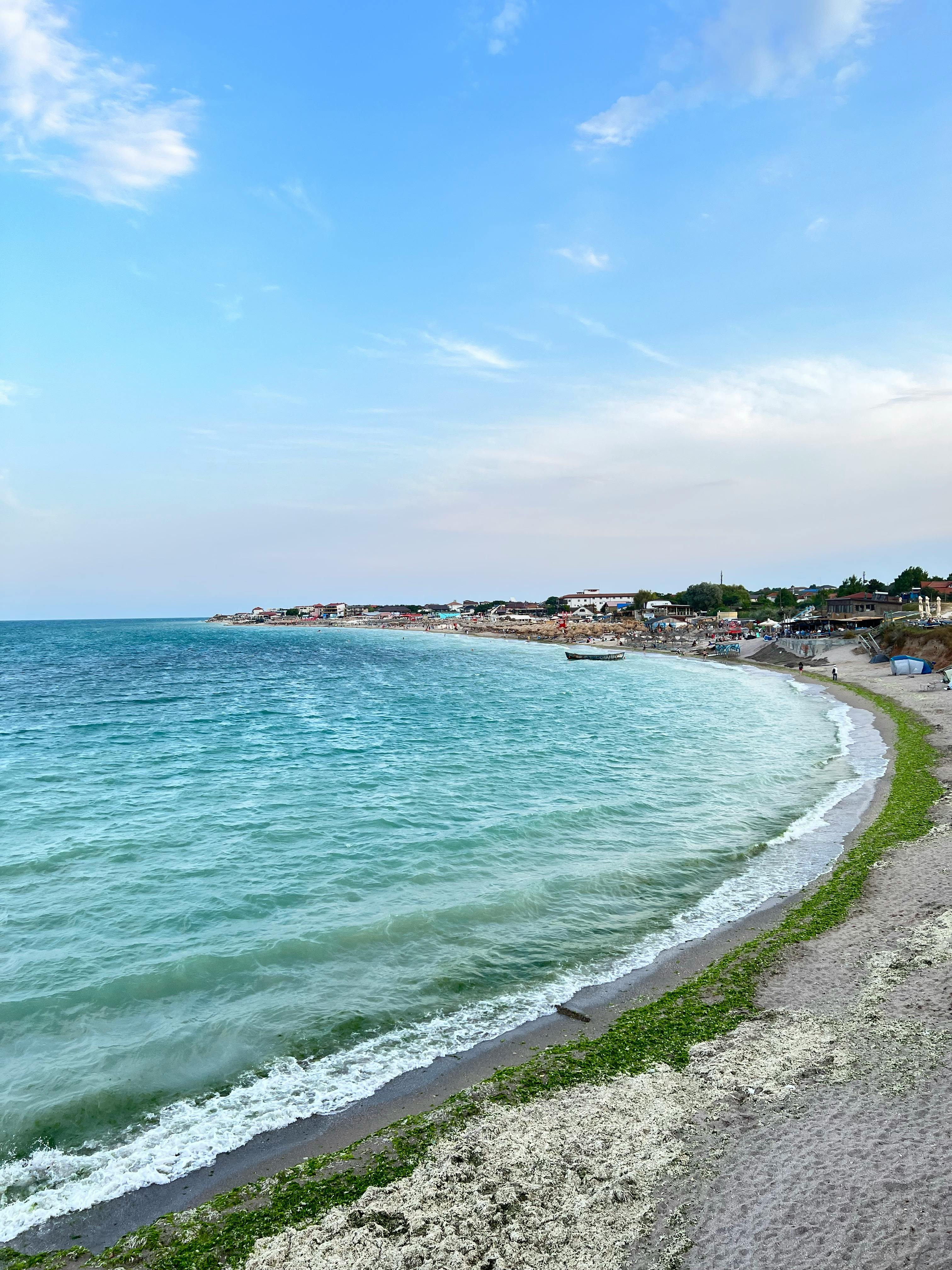 White Beach Shoreline Near Gray Rocks Under Blue Sky during Daytime ...