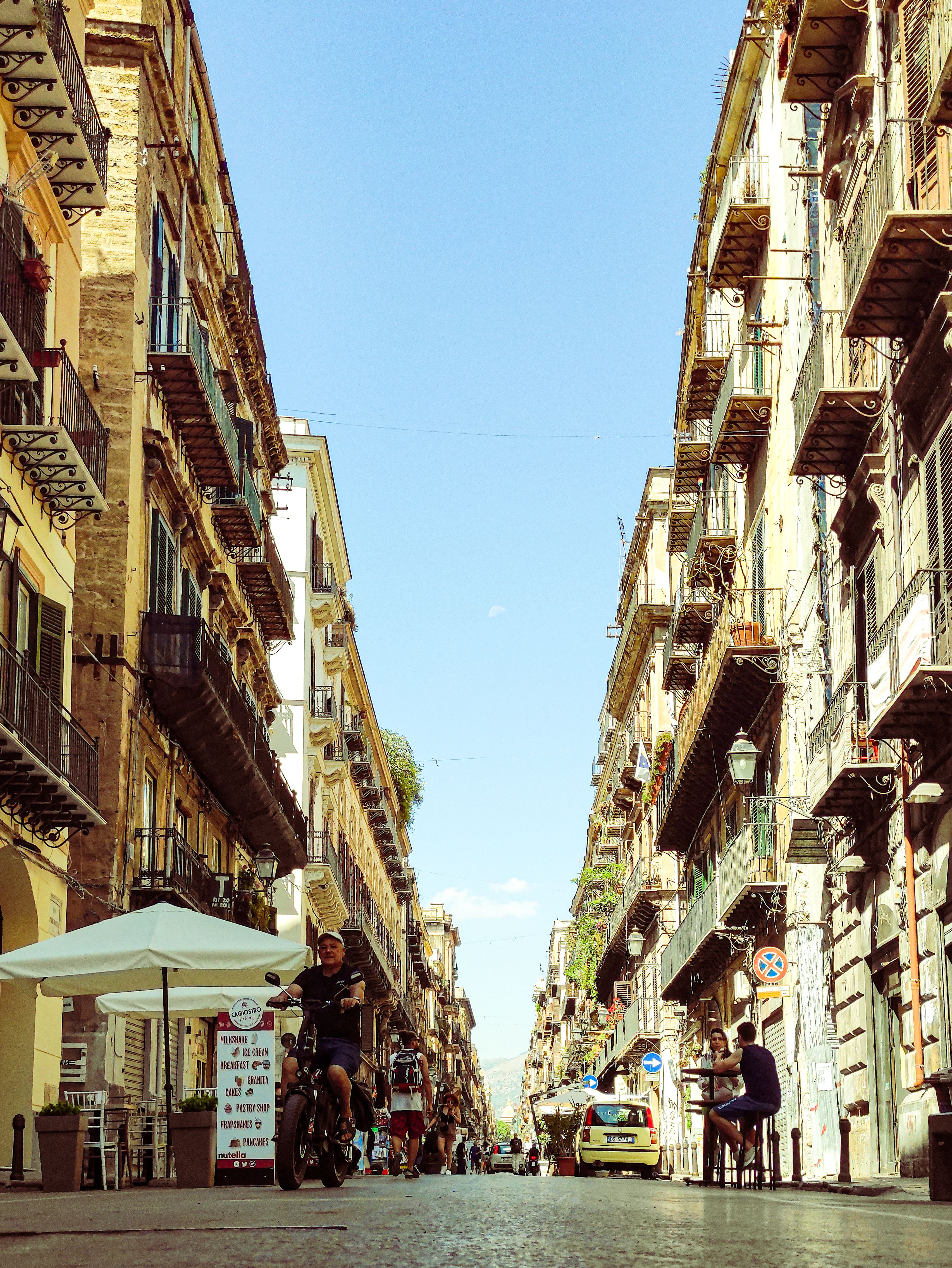 People on the Street between Buildings · Free Stock Photo