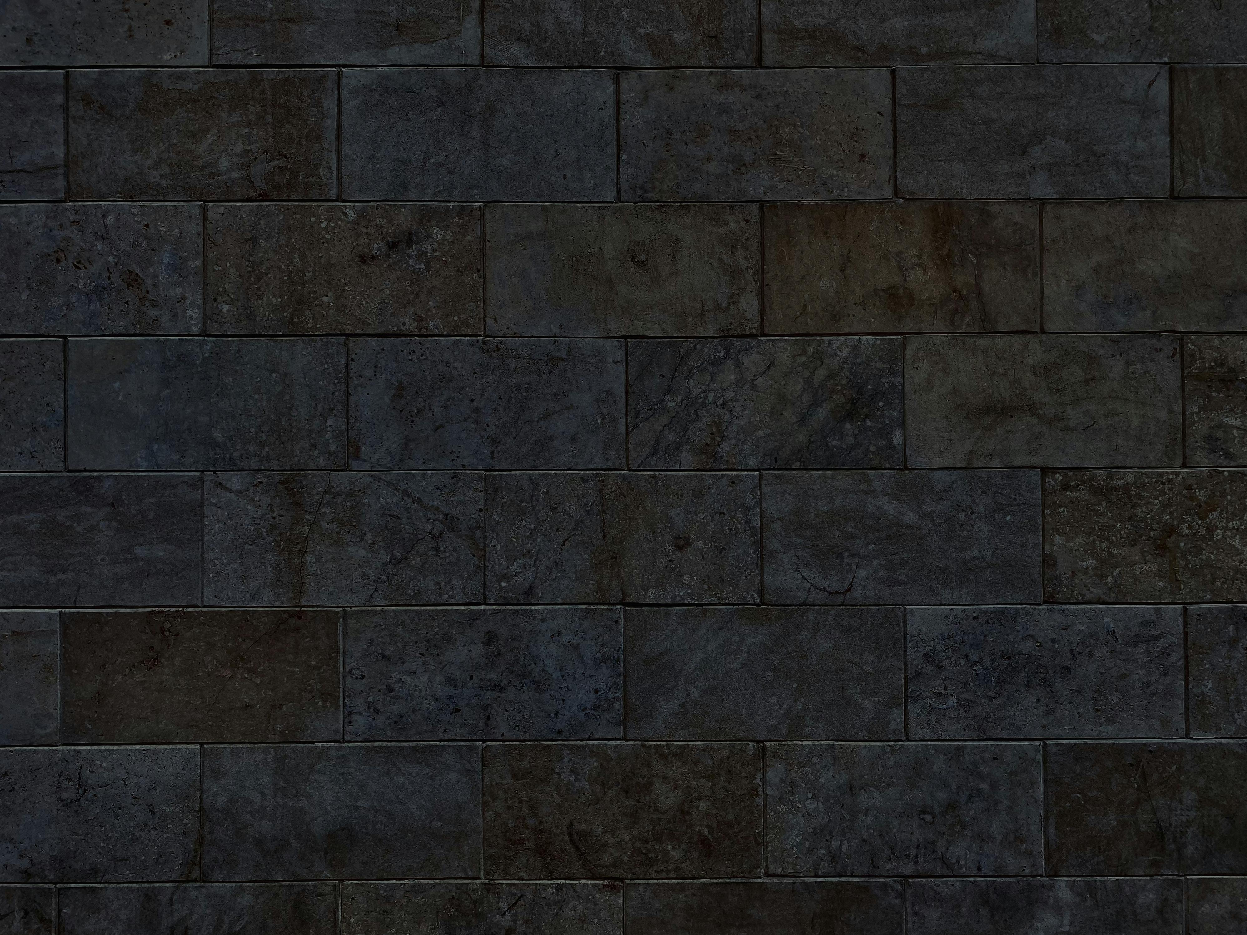 A Close-Up Shot of a Dark Brick Wall · Free Stock Photo