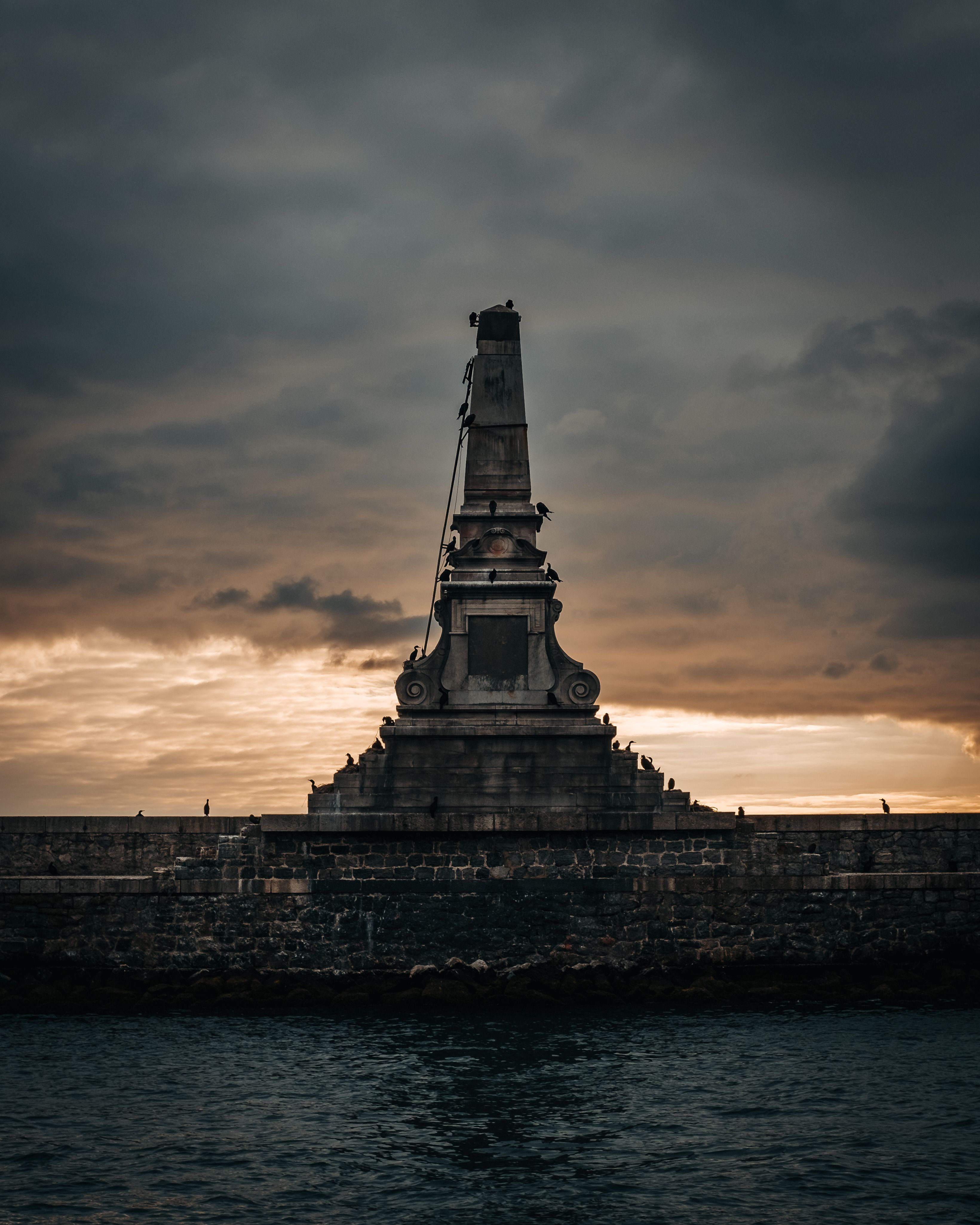 A Brown Concrete Monument Near Body of Water · Free Stock Photo
