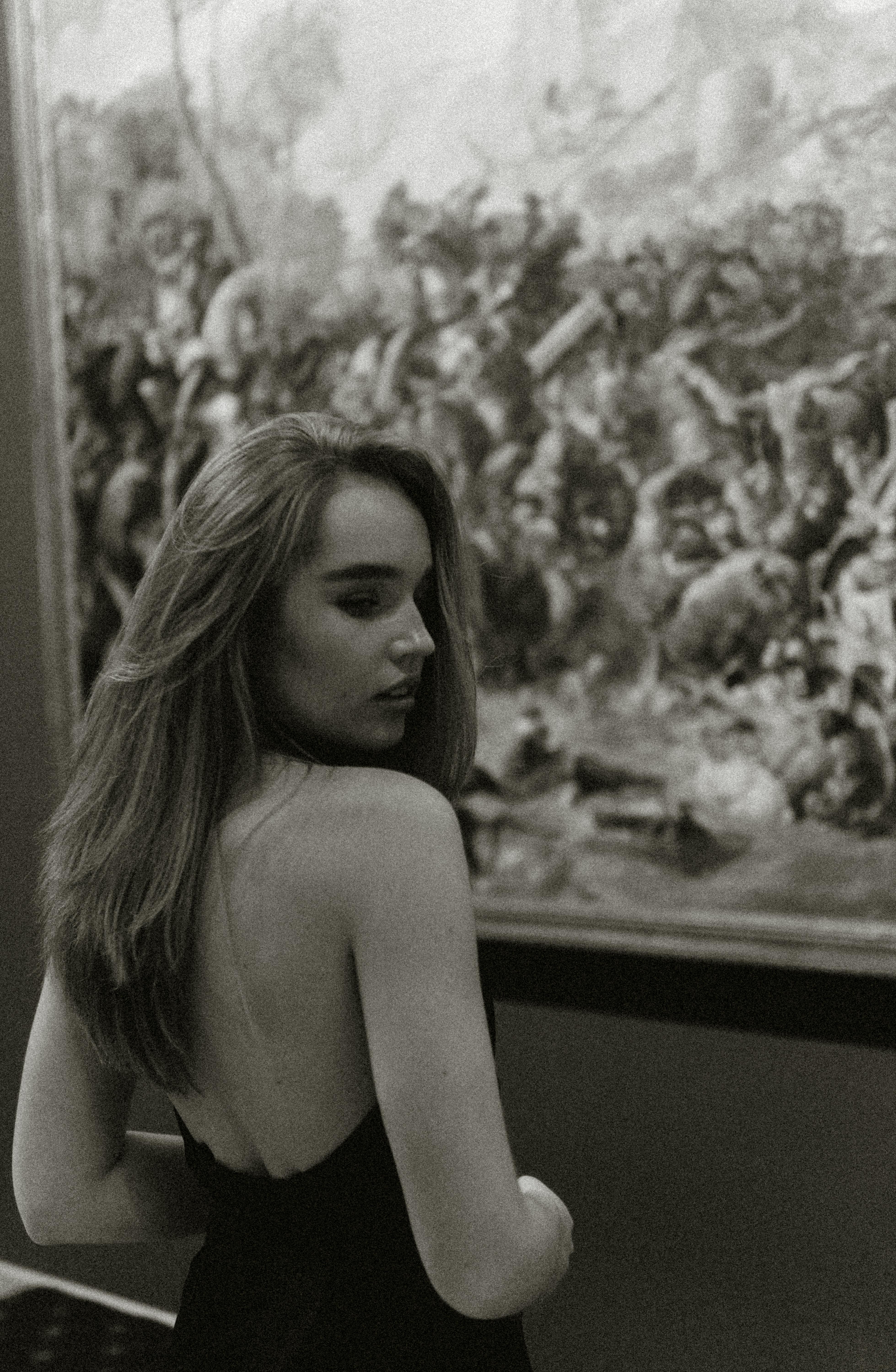 A Woman in Backless Black Dress Standing Beside the Painting · Free ...