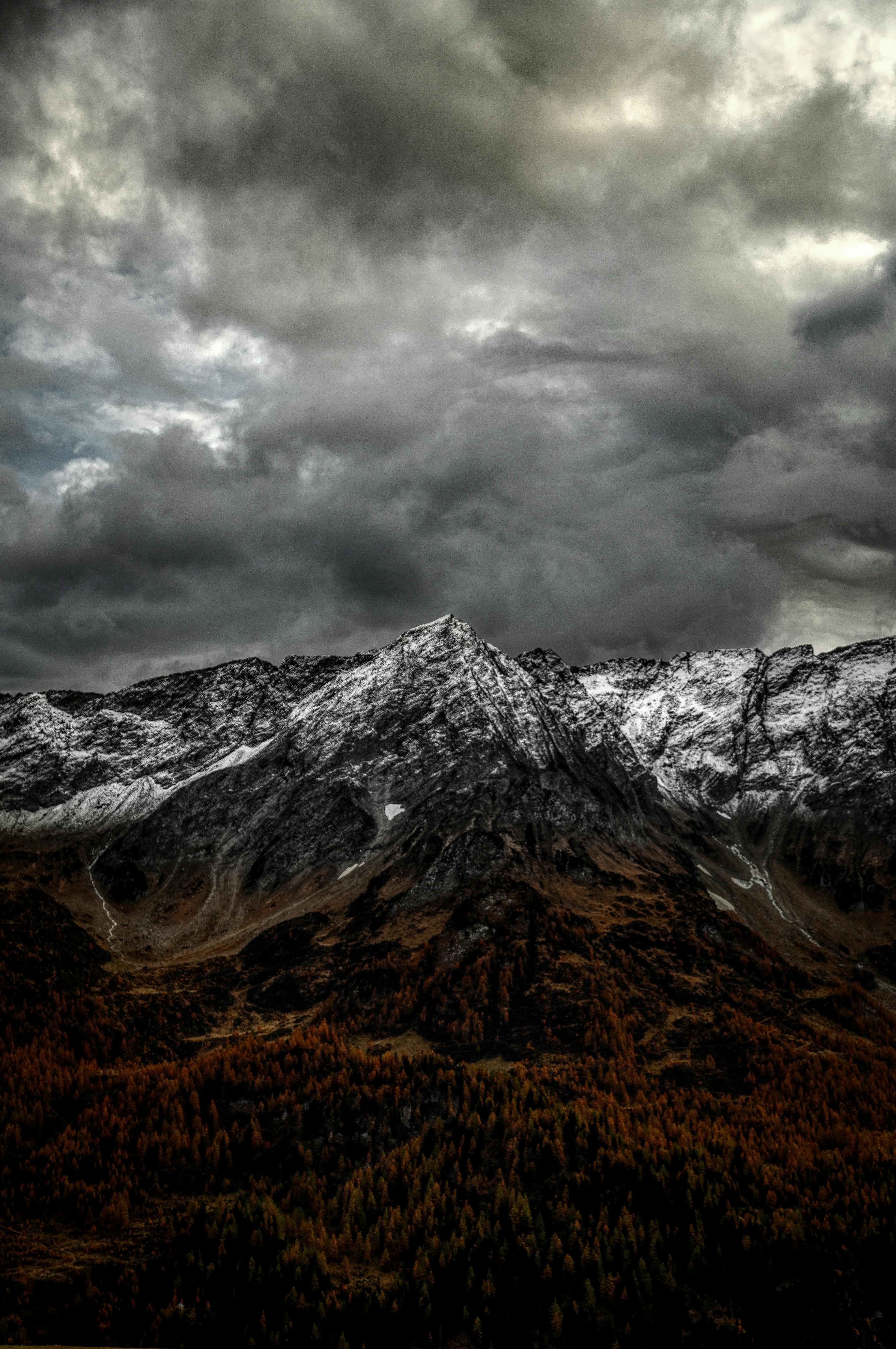 Snow Covered Mountains Under Dark Cloudy Sky · Free Stock Photo