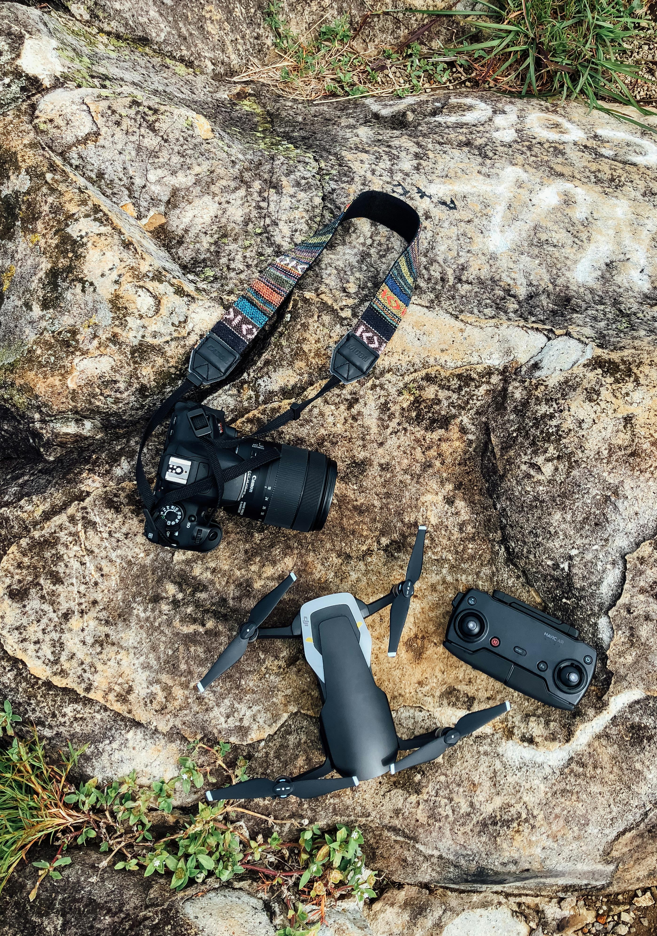 Black Dslr Camera Beside a Mavic Drone and Controller on Rock · Free ...