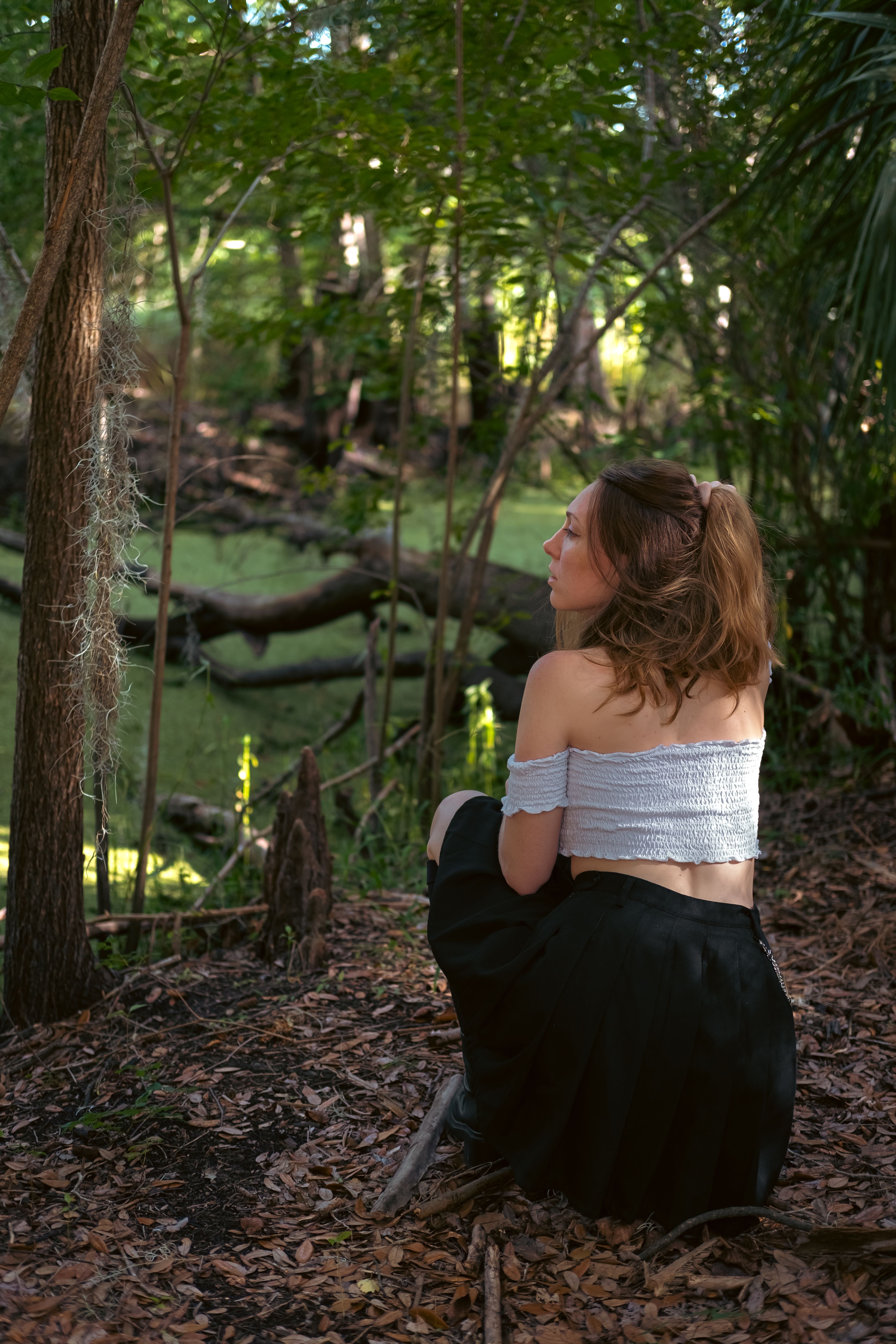 Woman Crouching in a Forest · Free Stock Photo