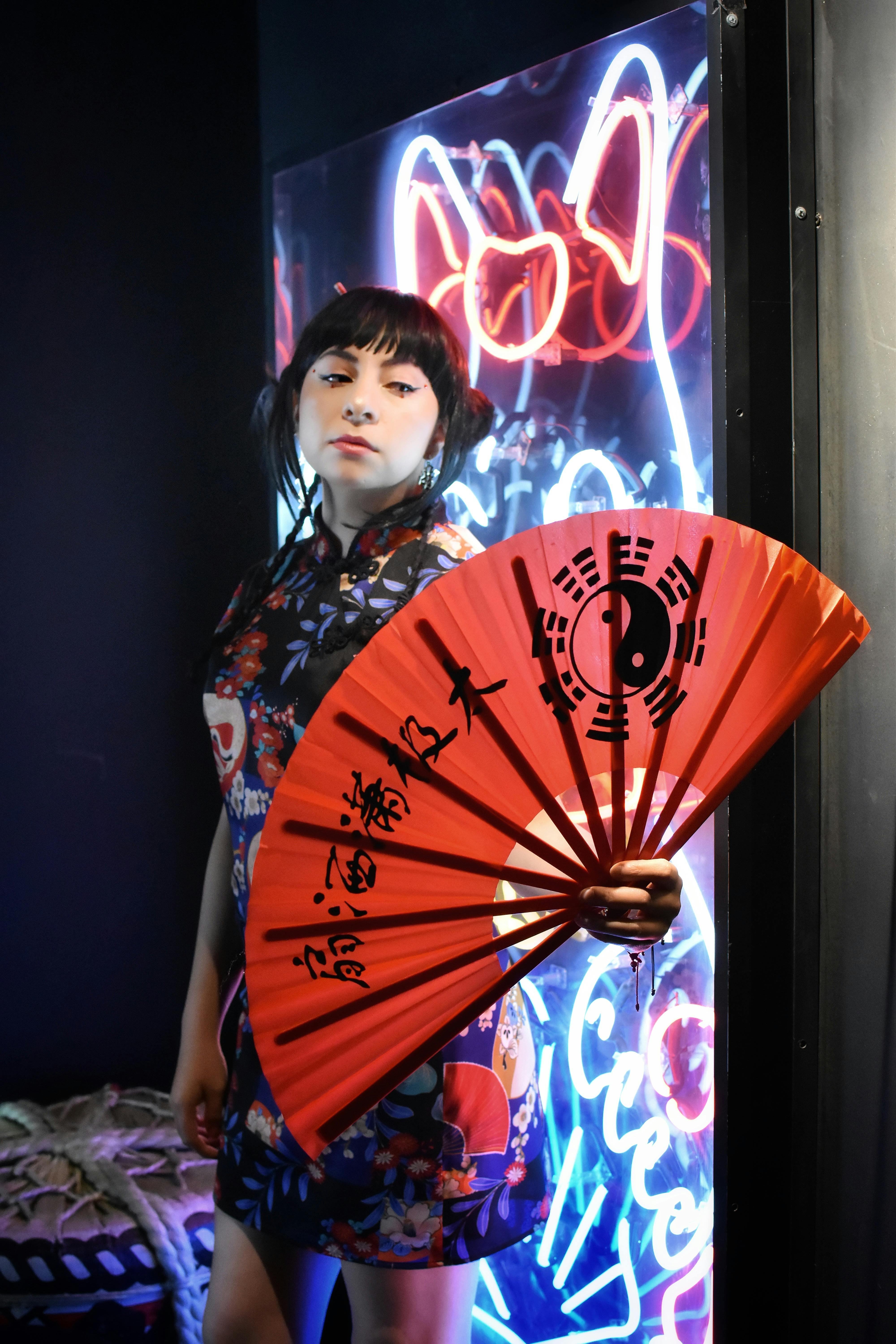 A Shocked Woman in Pink Dress Sitting on Wooden Table · Free Stock Photo