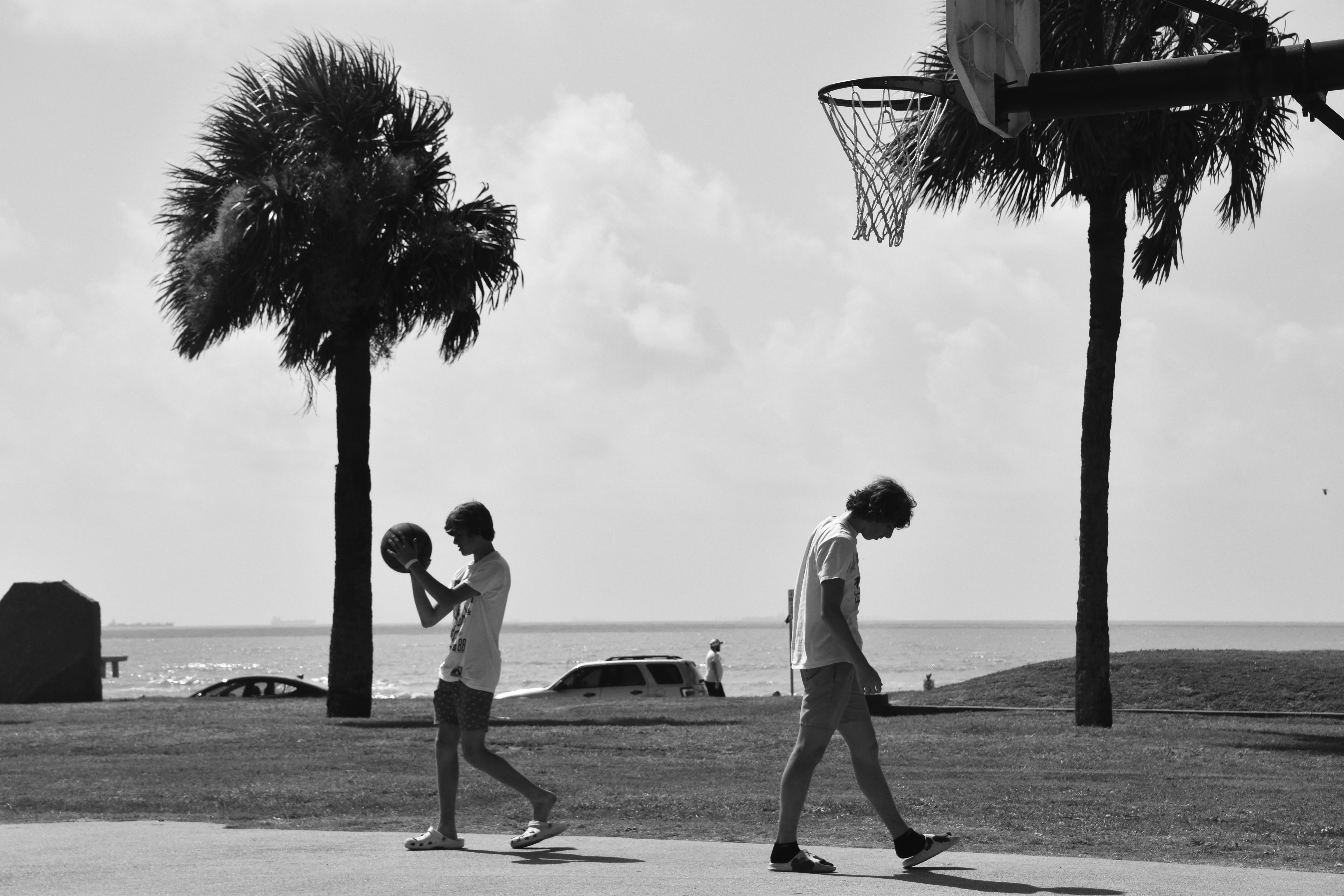 A Grayscale Photo of Men in White Shirts Walking at the Basketball ...