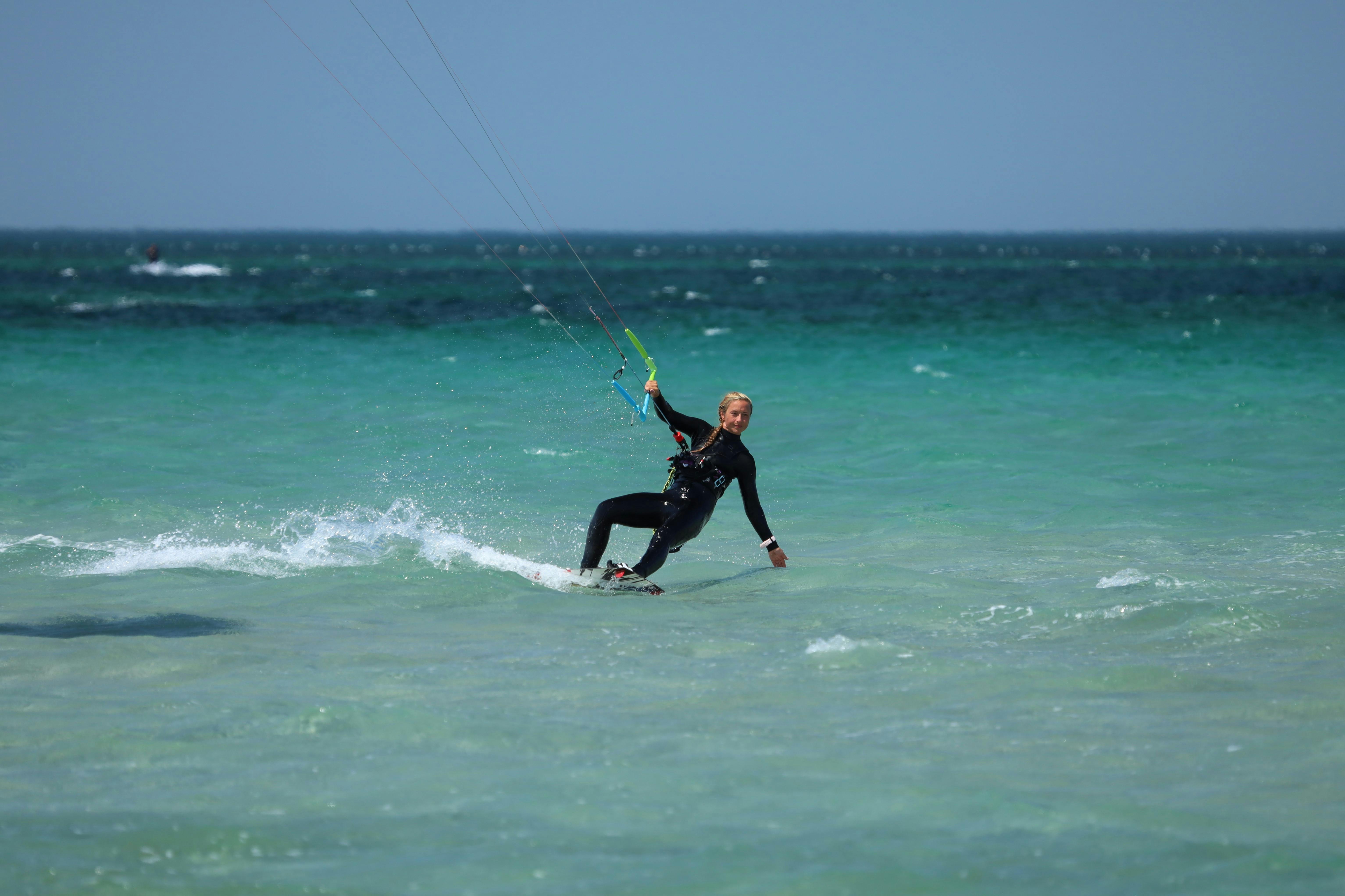 A Woman in Black Wetsuit Kitesurfing on Sea · Free Stock Photo