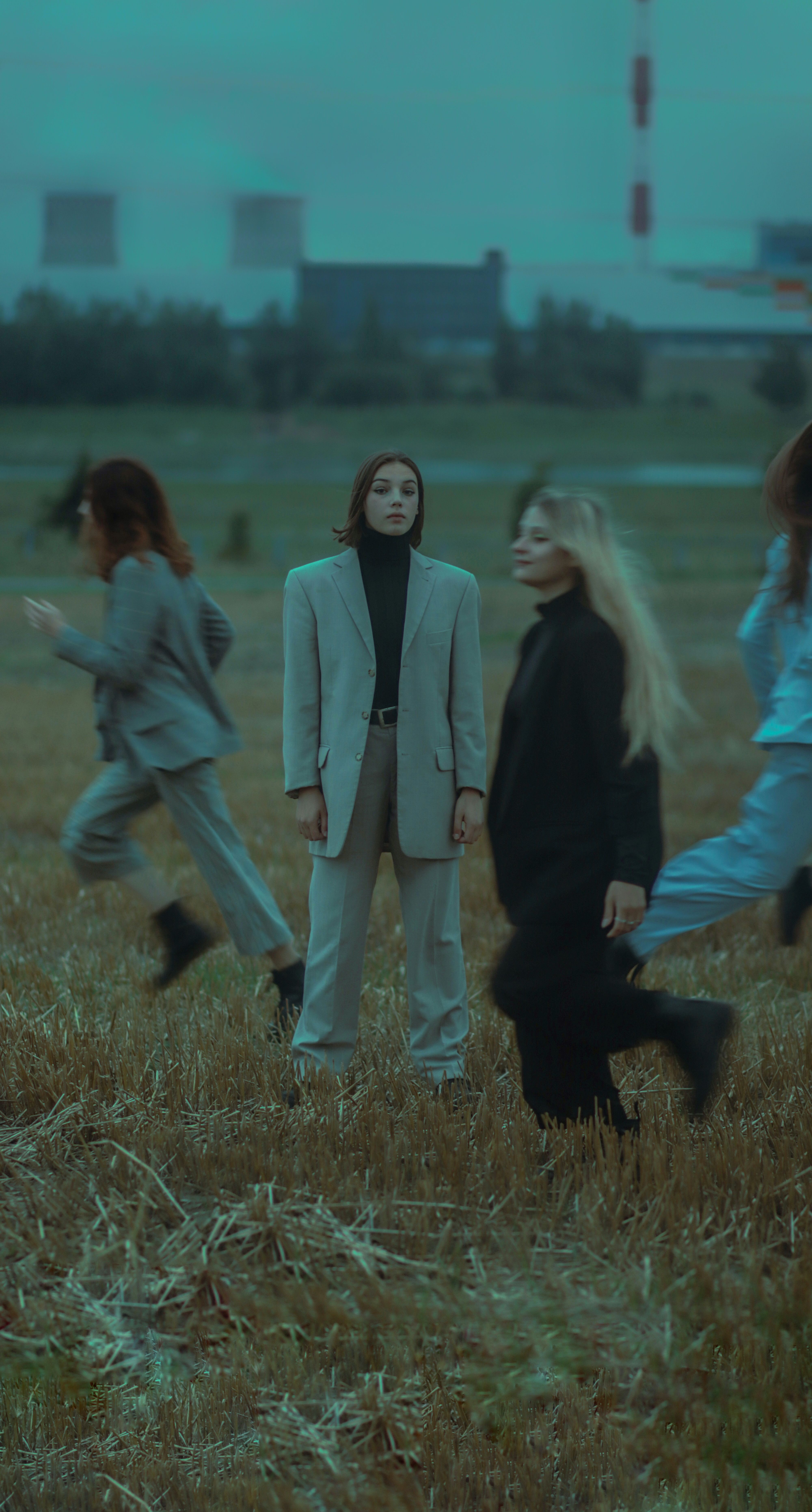 One Woman in a Suit Standing Still and Other Women Running Around Her ...