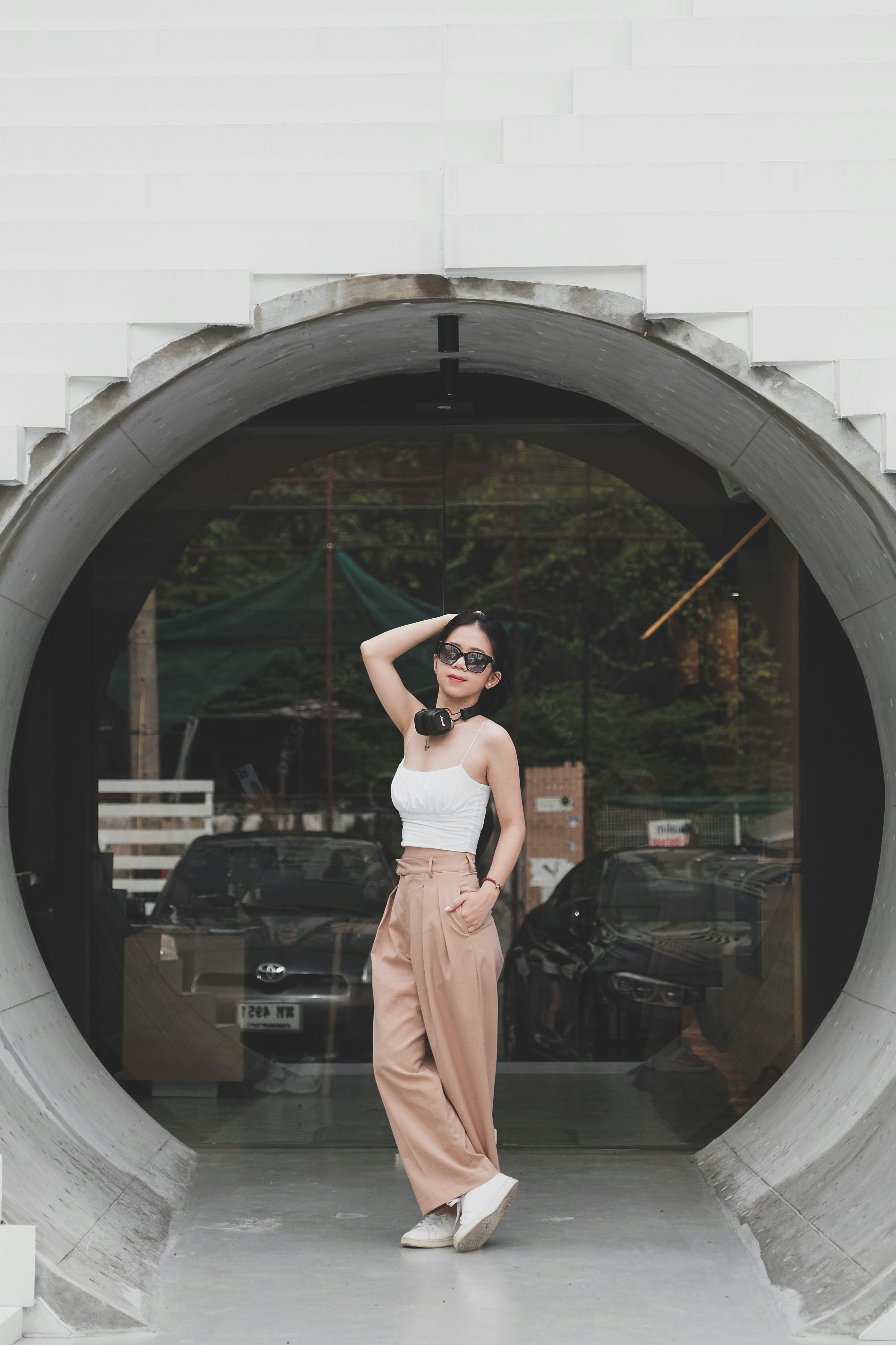 Stylish Girl in Sunglasses Posing near Green Wall · Free Stock Photo