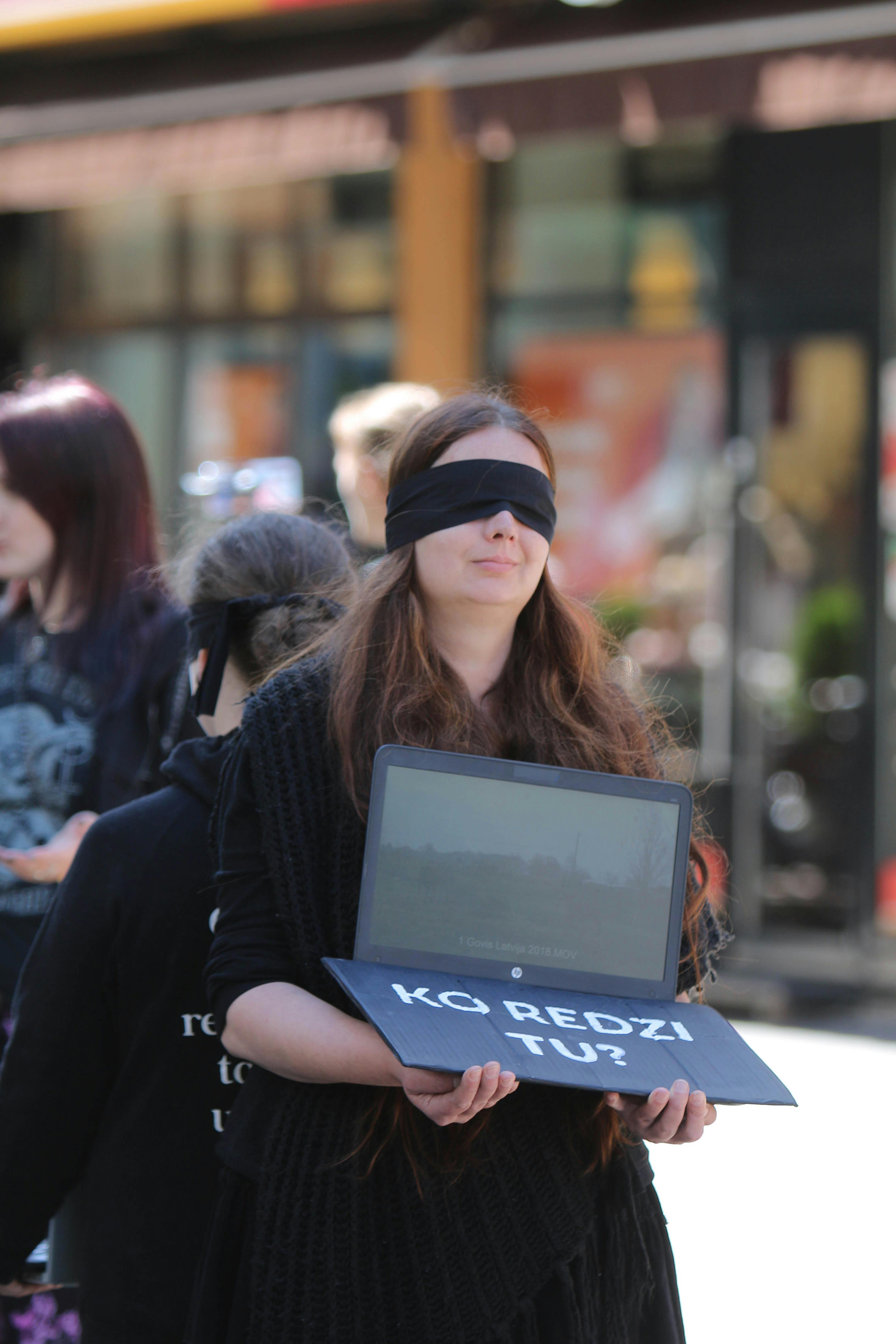 A Blindfolded Woman in Black Long Sleeve Shirt Holding Black Tablet ...