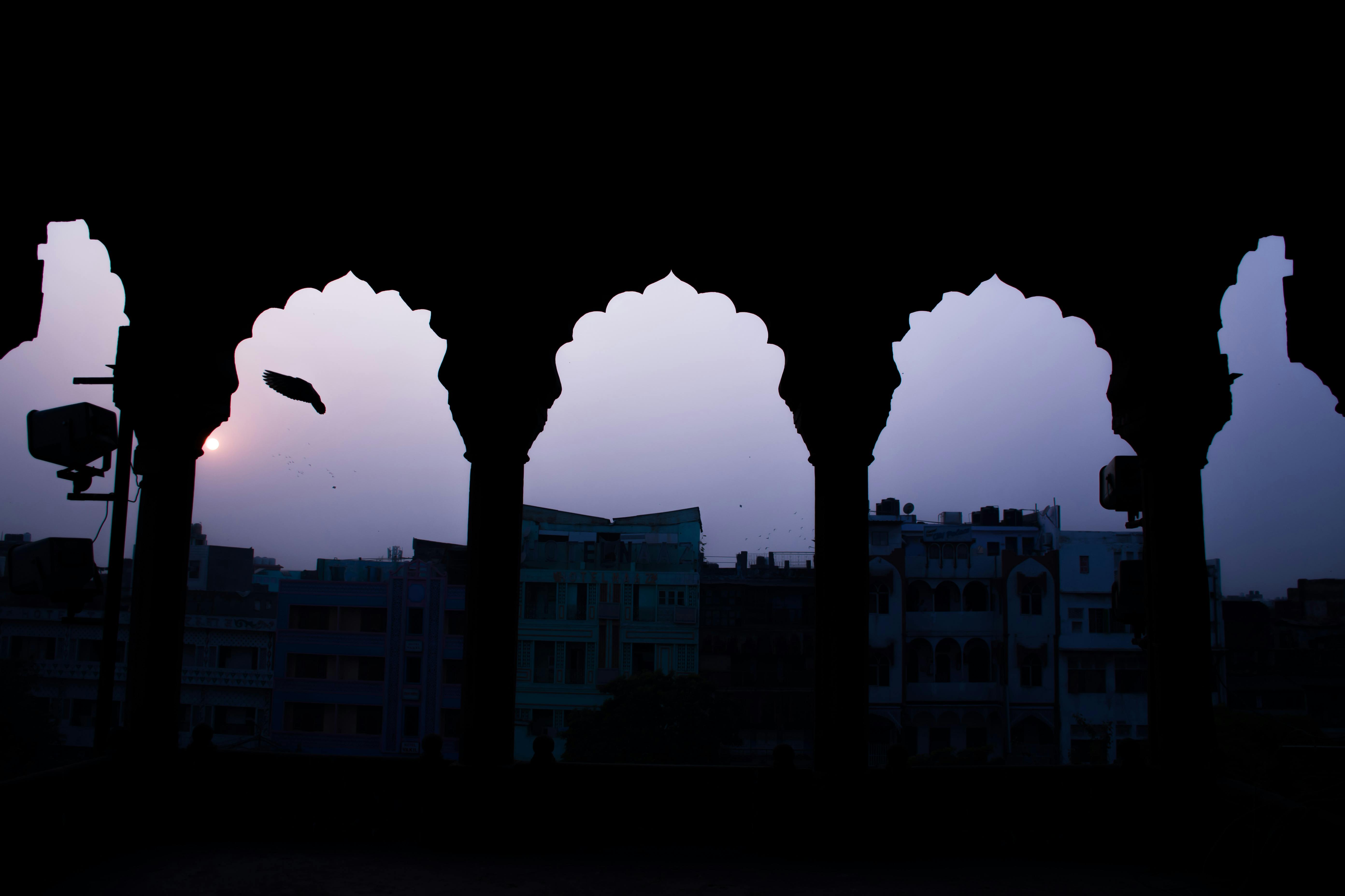Silhouette of Archways Framing a City View · Free Stock Photo