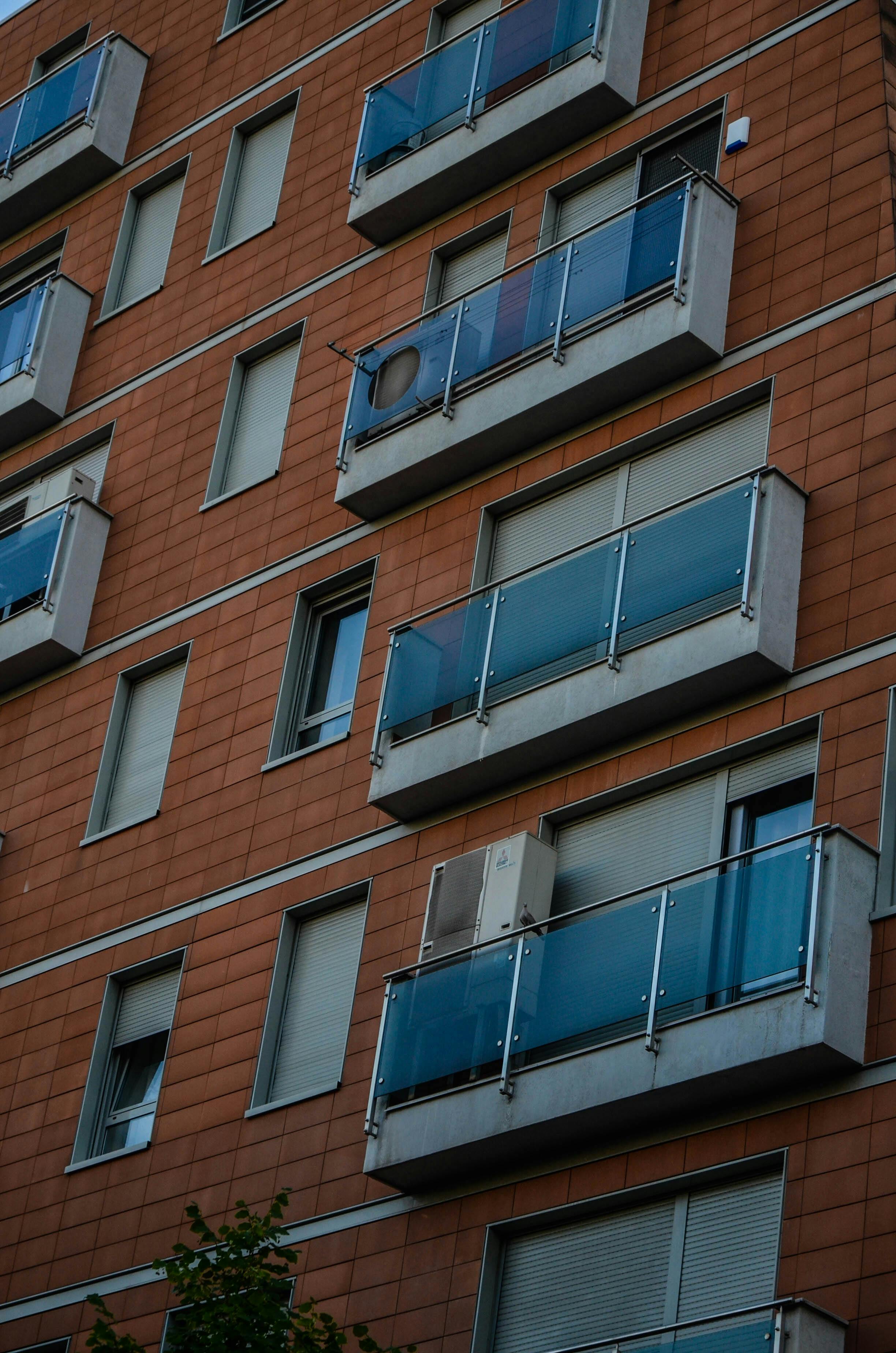 People Looking Through the Window of a Brick House · Free Stock Photo