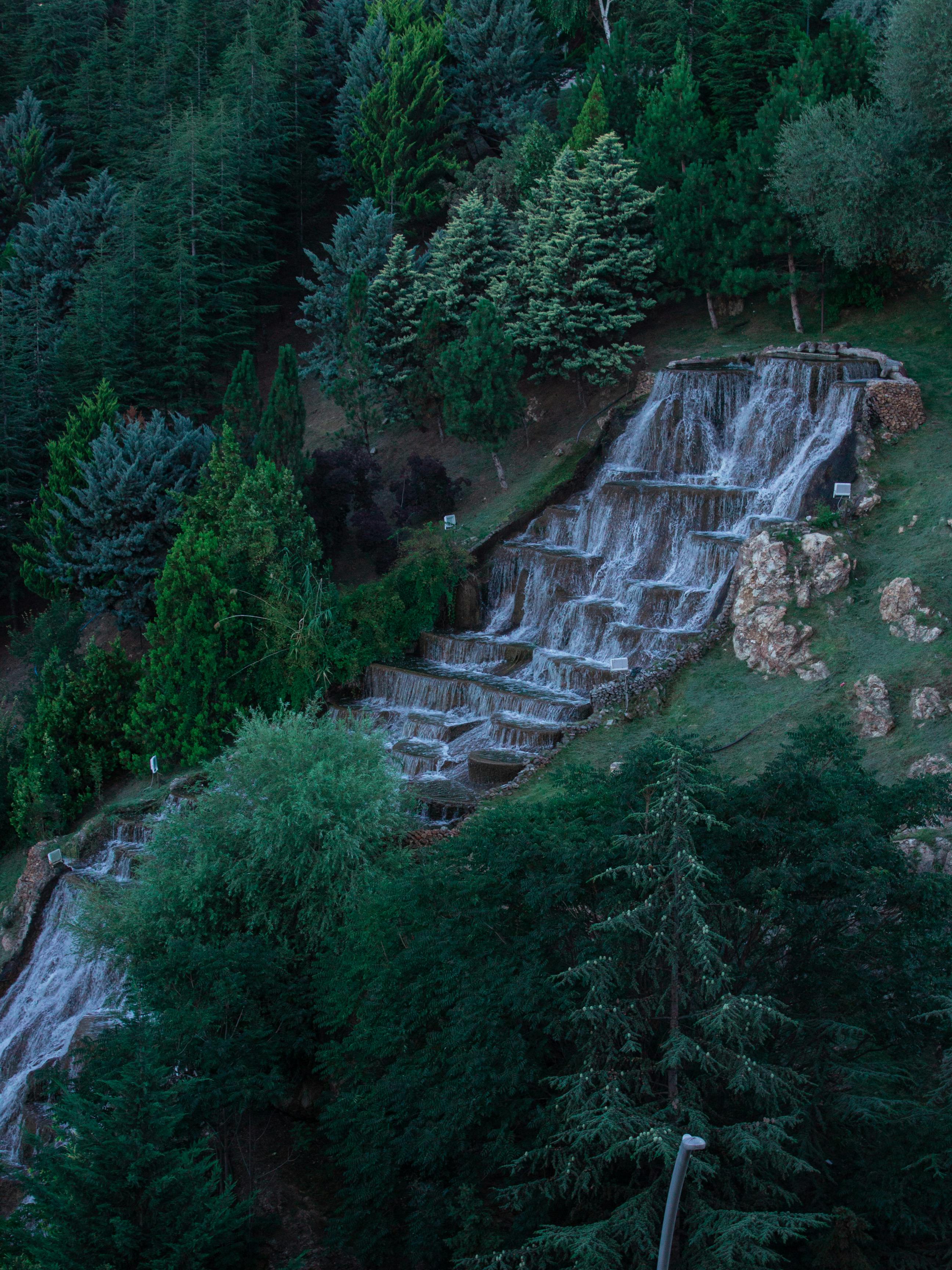 Cascading Waterfalls from the Steps Between Green Trees · Free Stock Photo