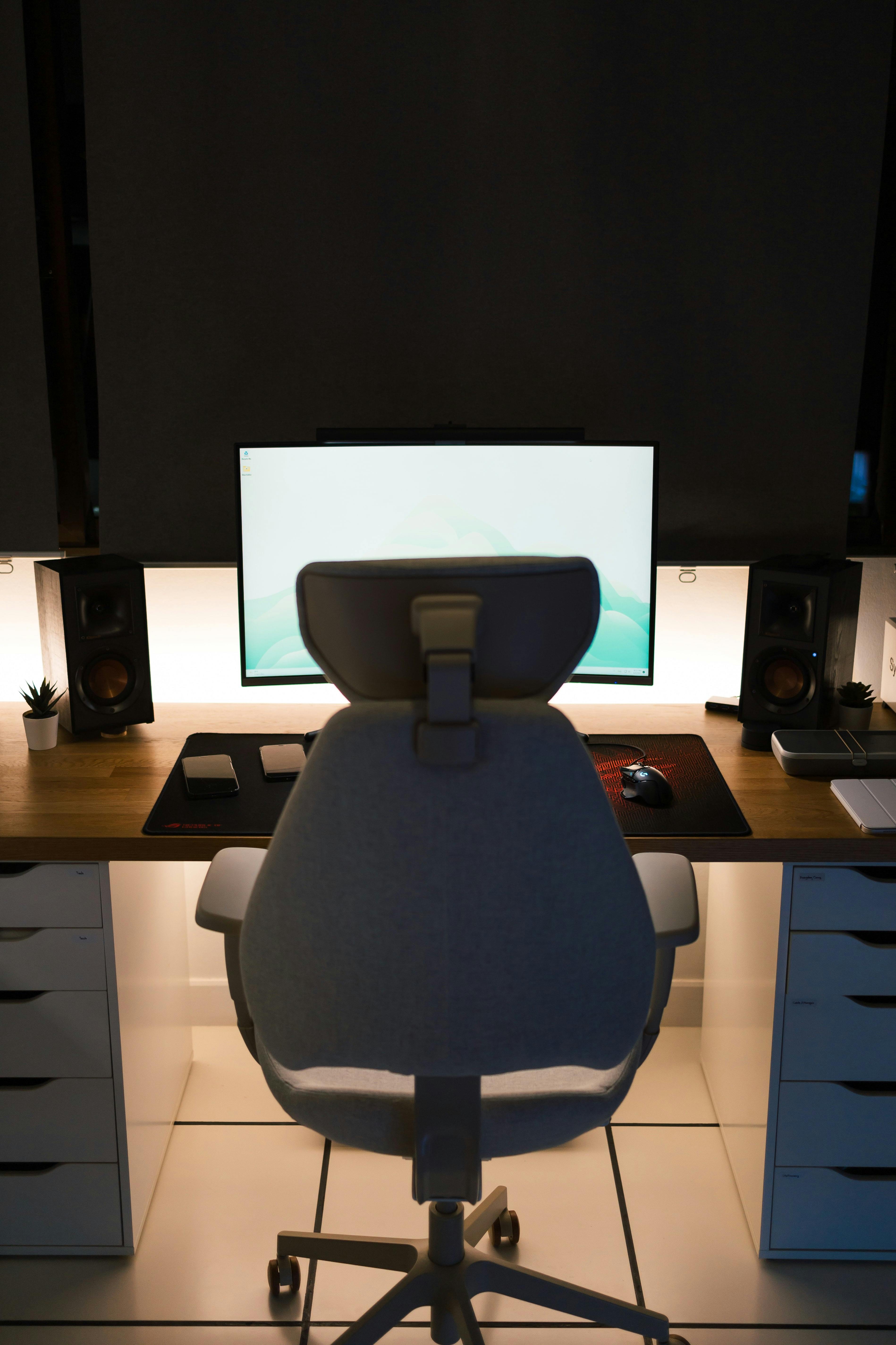 A White Office Chair Beside Desk with Computer · Free Stock Photo