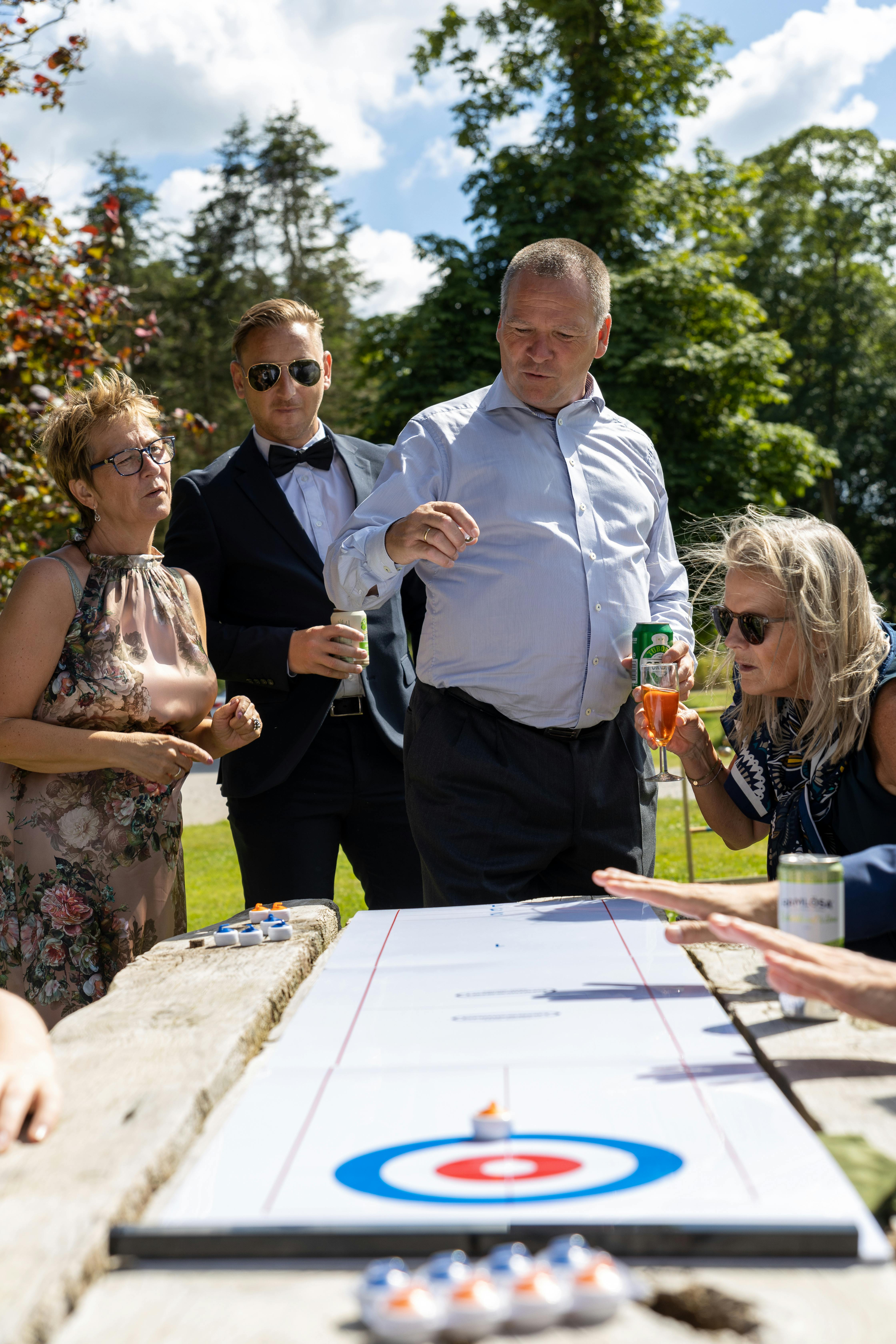 People Playing Table Curling on Outdoor Event · Free Stock Photo