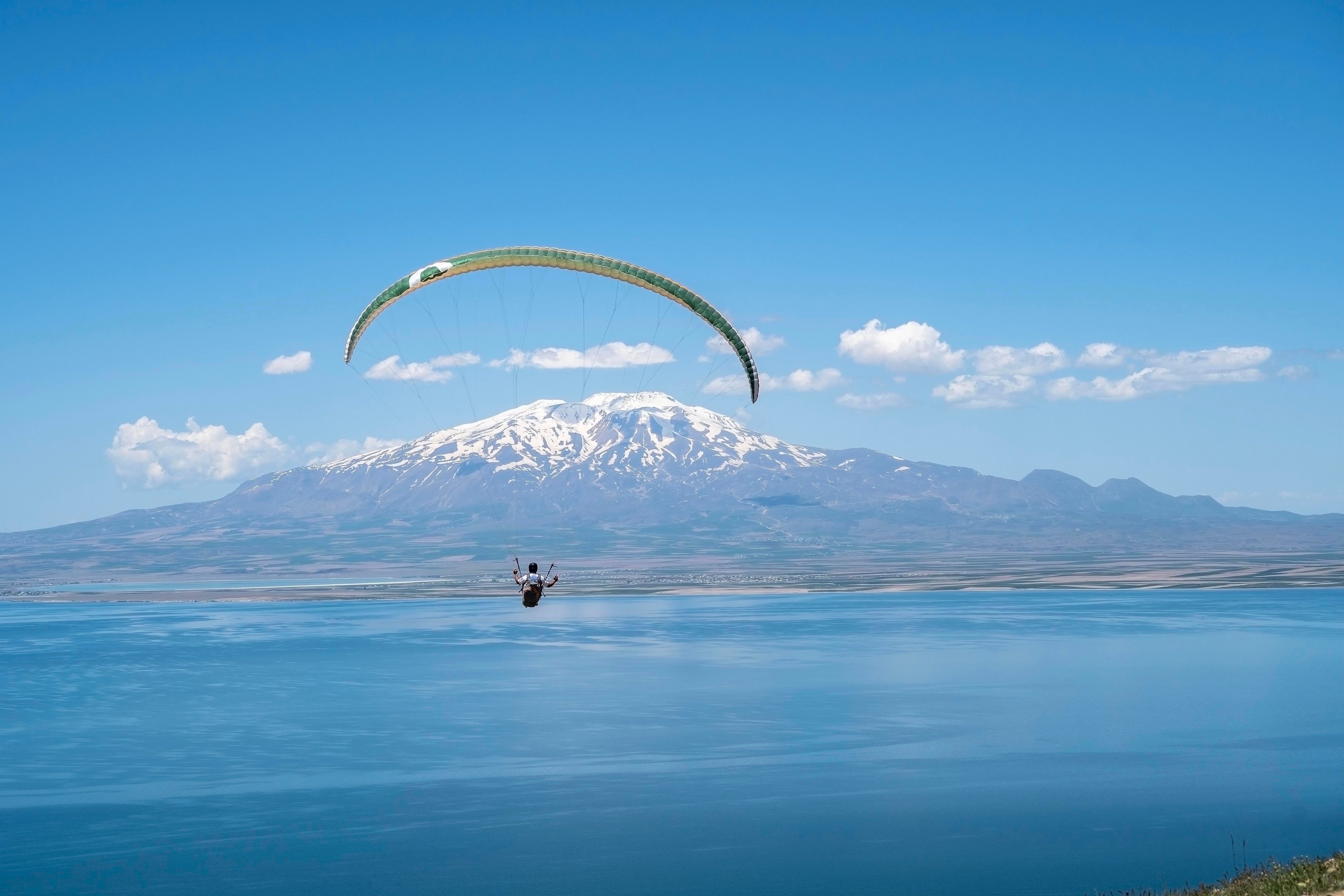 A Man Paragliding Over the Ocean · Free Stock Photo