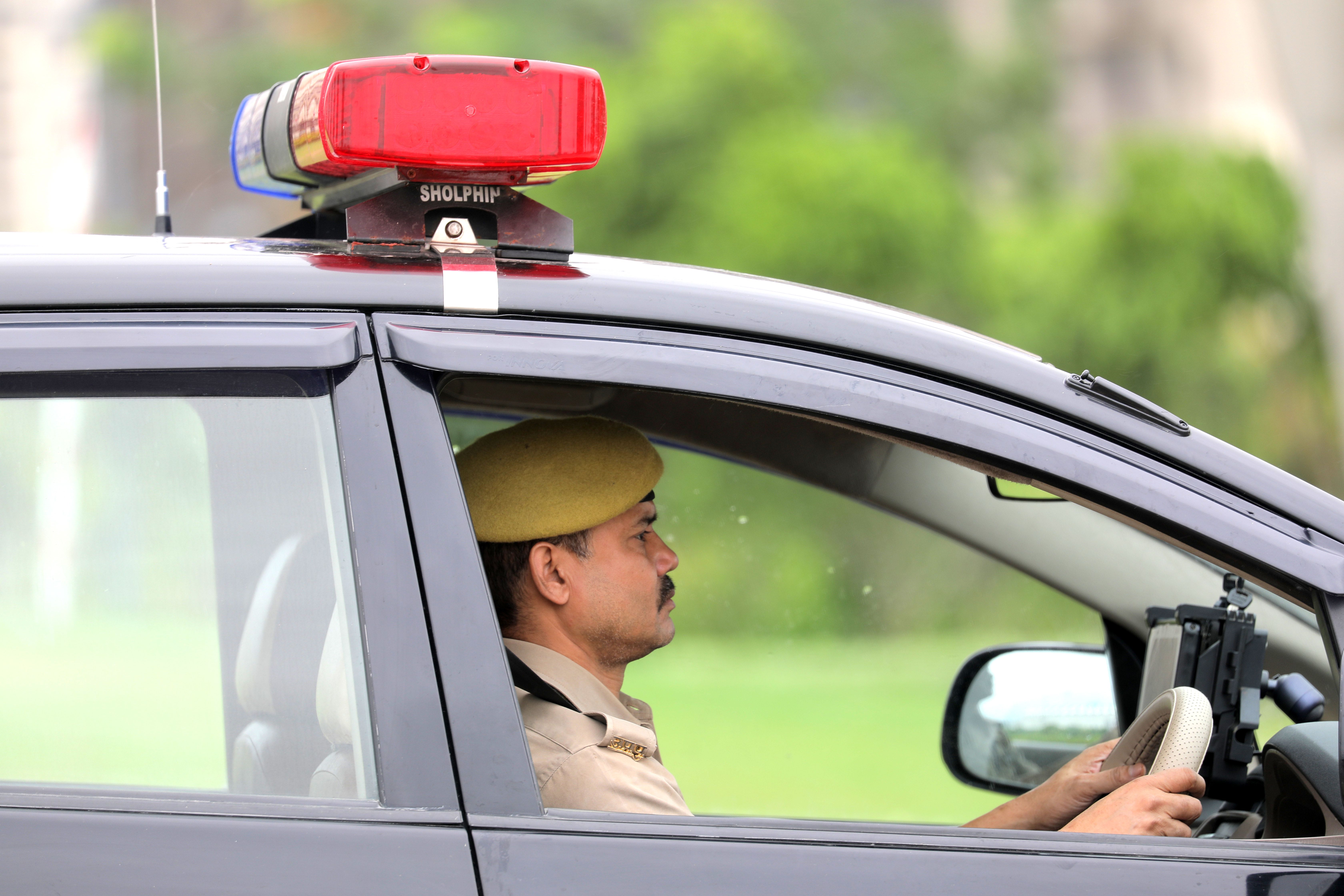 Policeman sitting in police car driving on street · Free Stock Photo