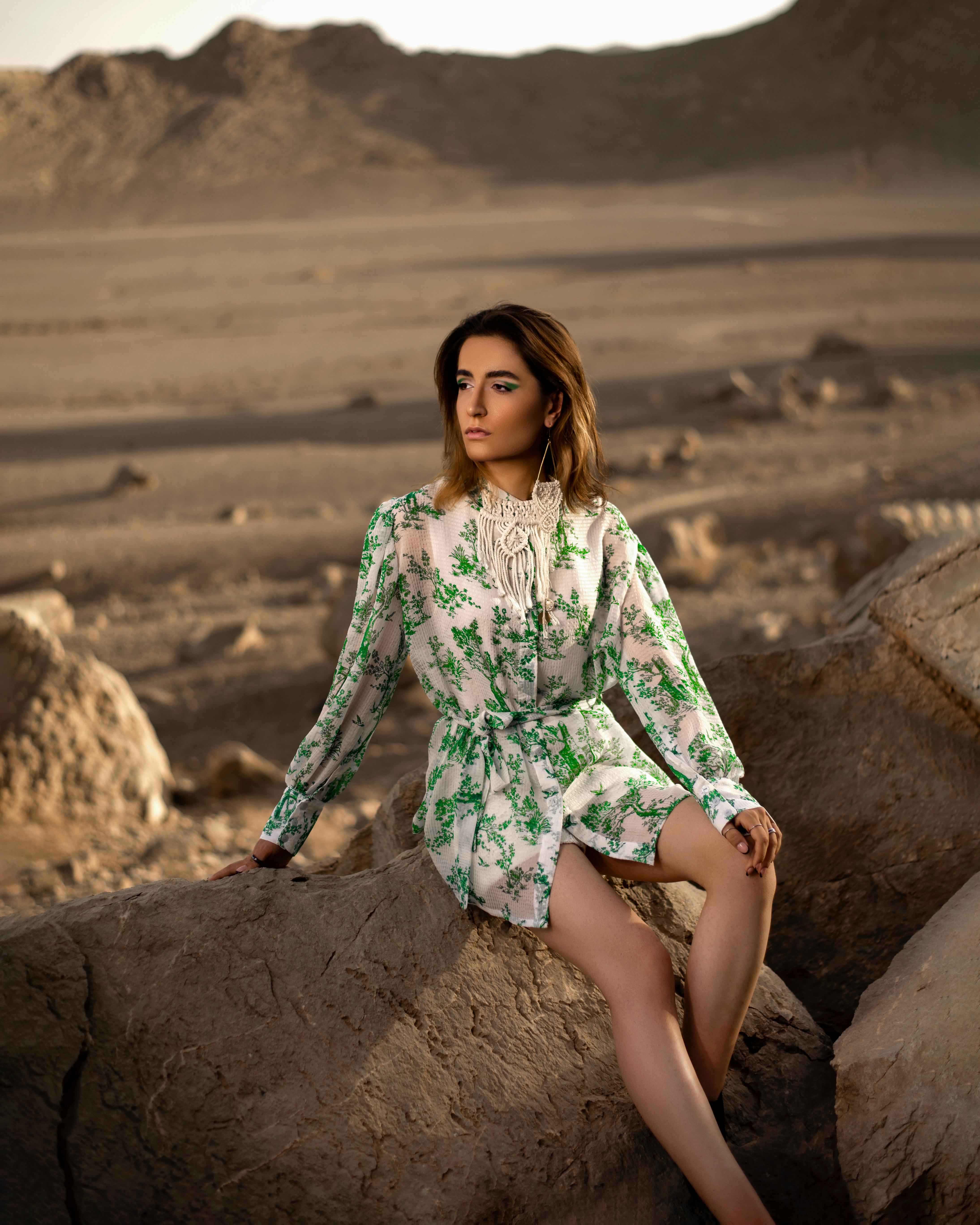 Fashion Model Sitting on Rock in Mountains Landscape · Free Stock Photo