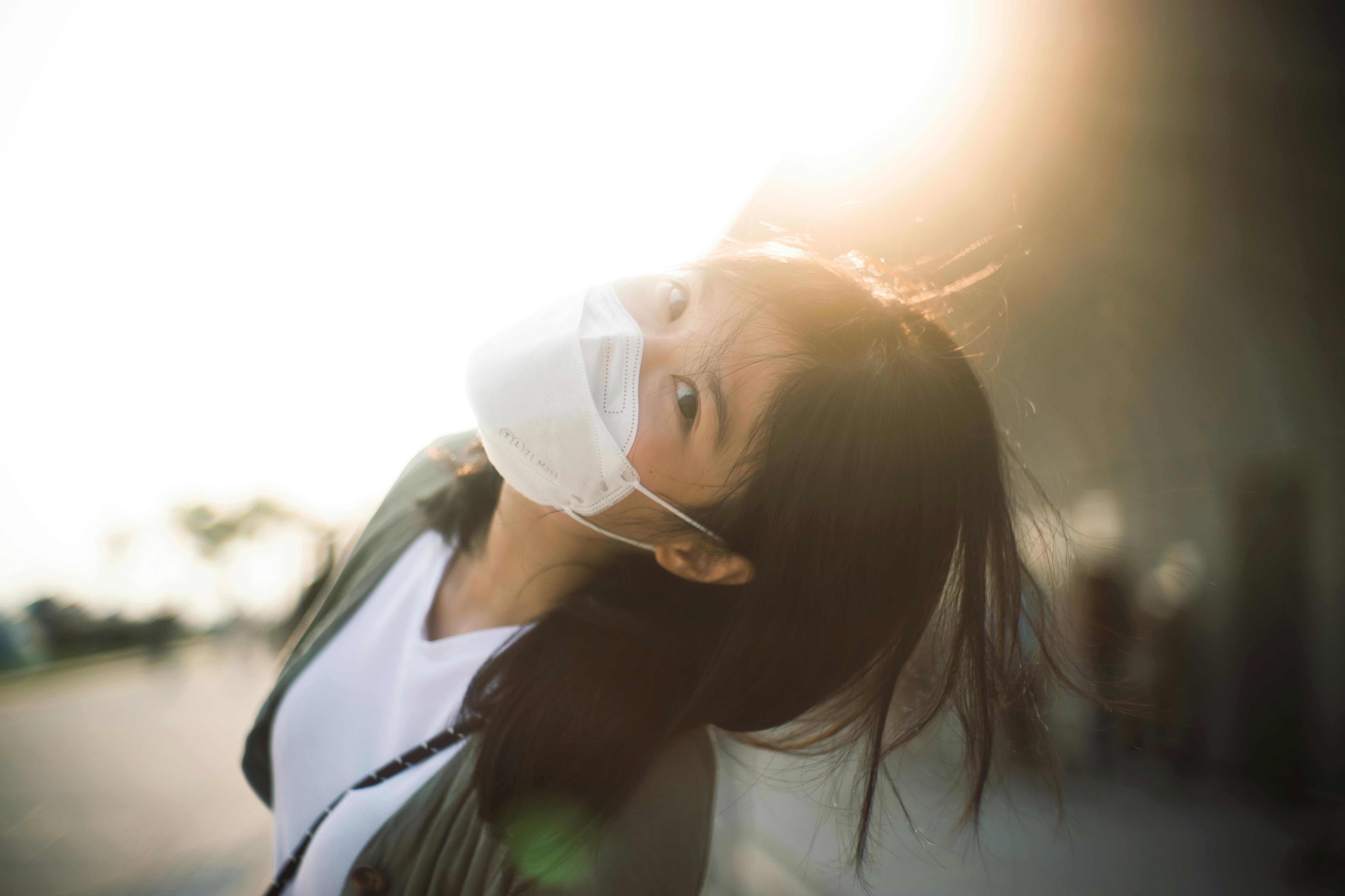 Close-Up Shot of a Woman Wearing White Face Mask · Free Stock Photo